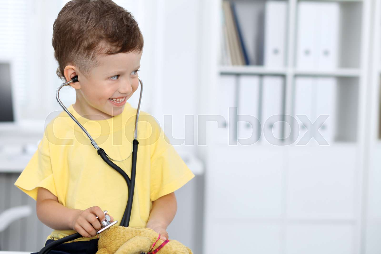 Doctor and patient in hospital. Happy little boy having fun while being ...