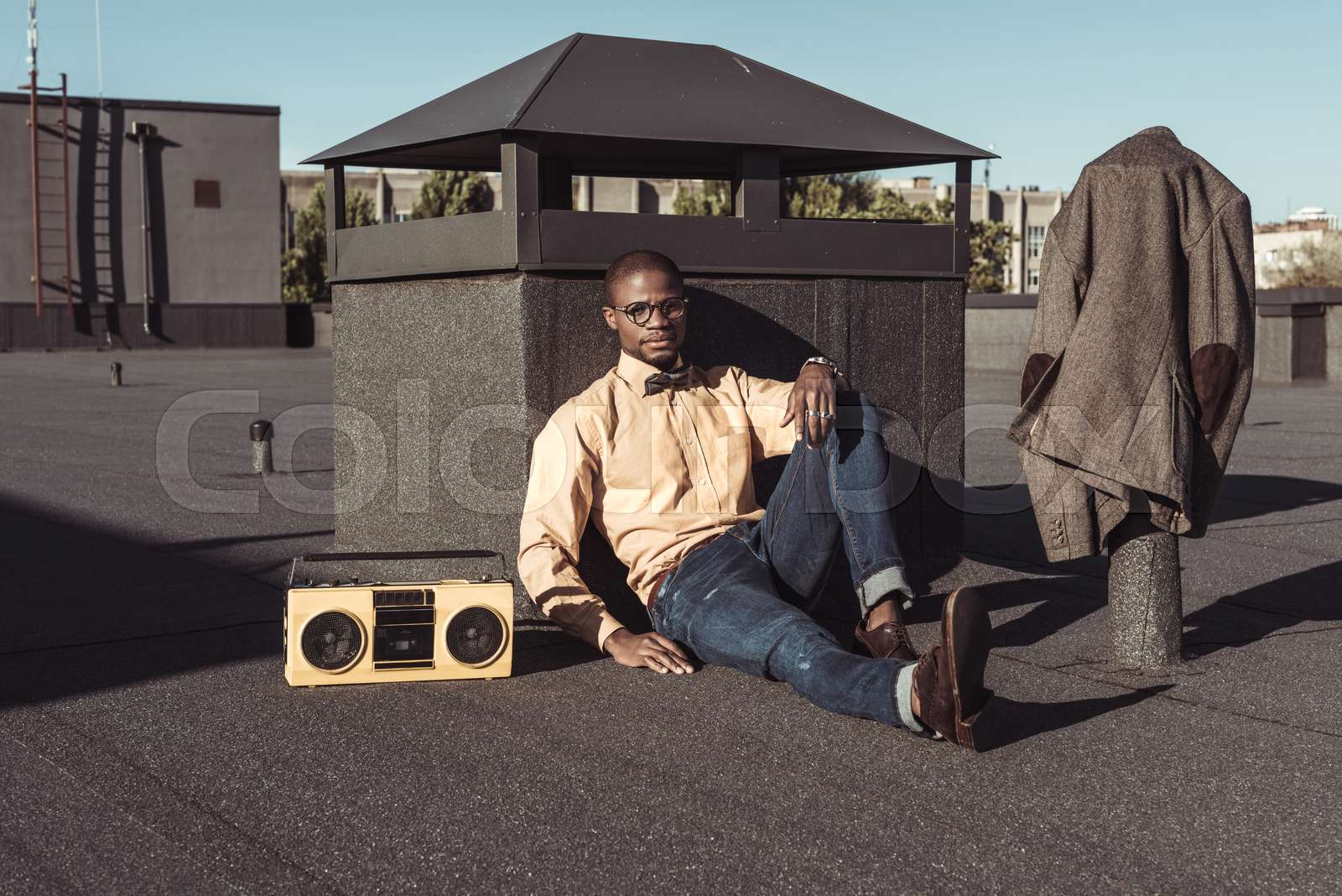 african american man sitting on rooftop with boombox | Stock image ...