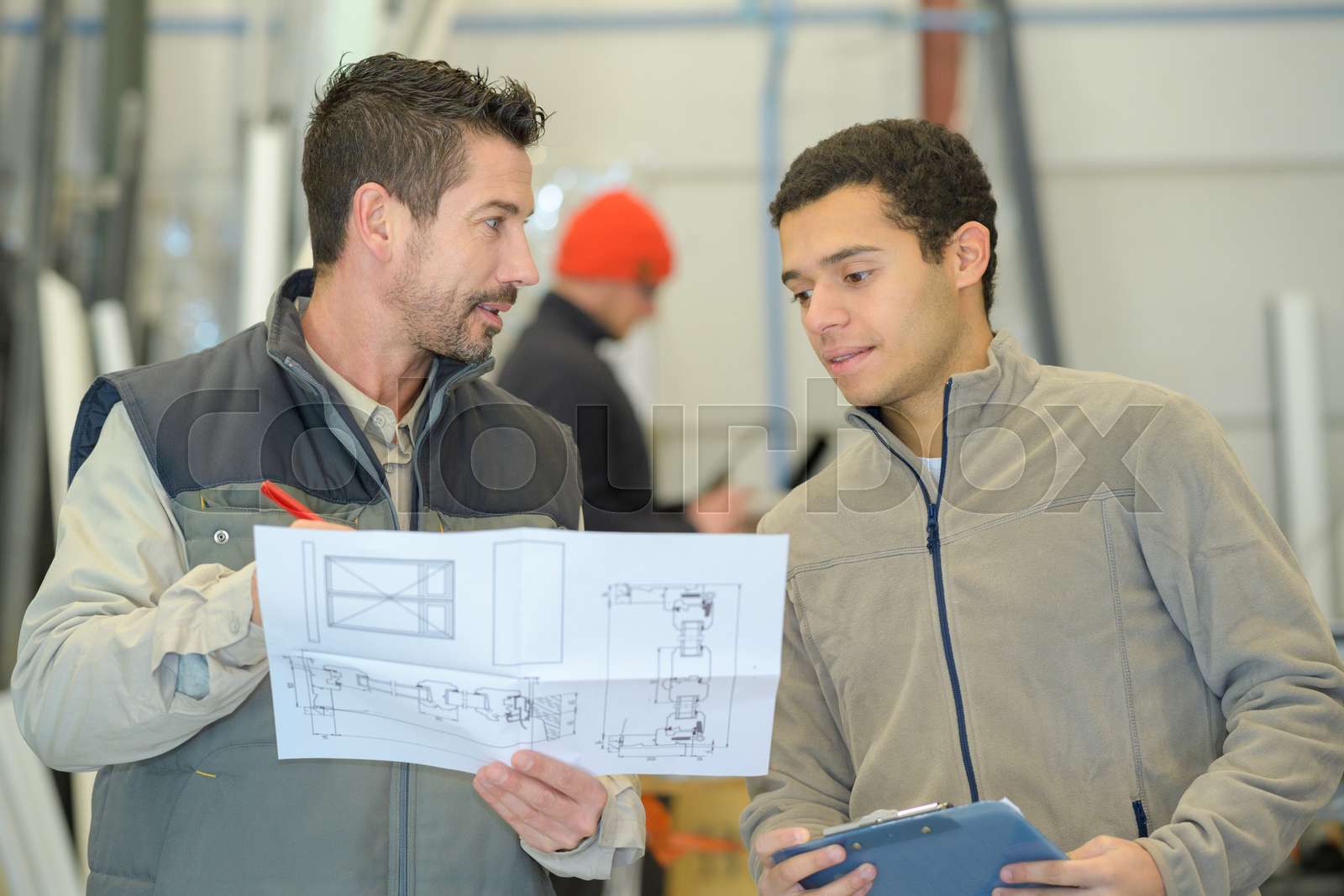 male engineer and worker checking indoor building construction site ...