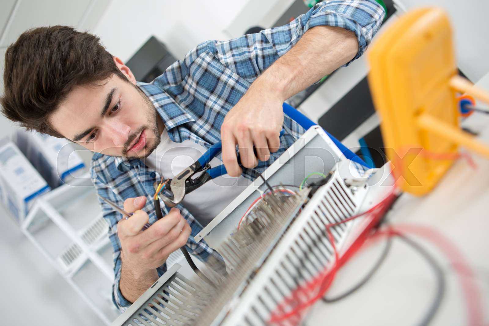 man holding tools while fixing a device | Stock image | Colourbox