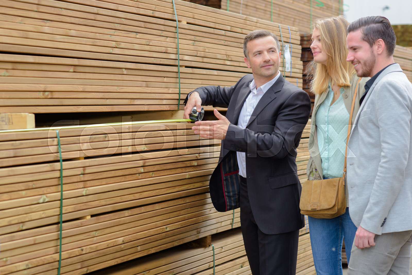 male seller and clients in wood factory yard choosing boards | Stock ...