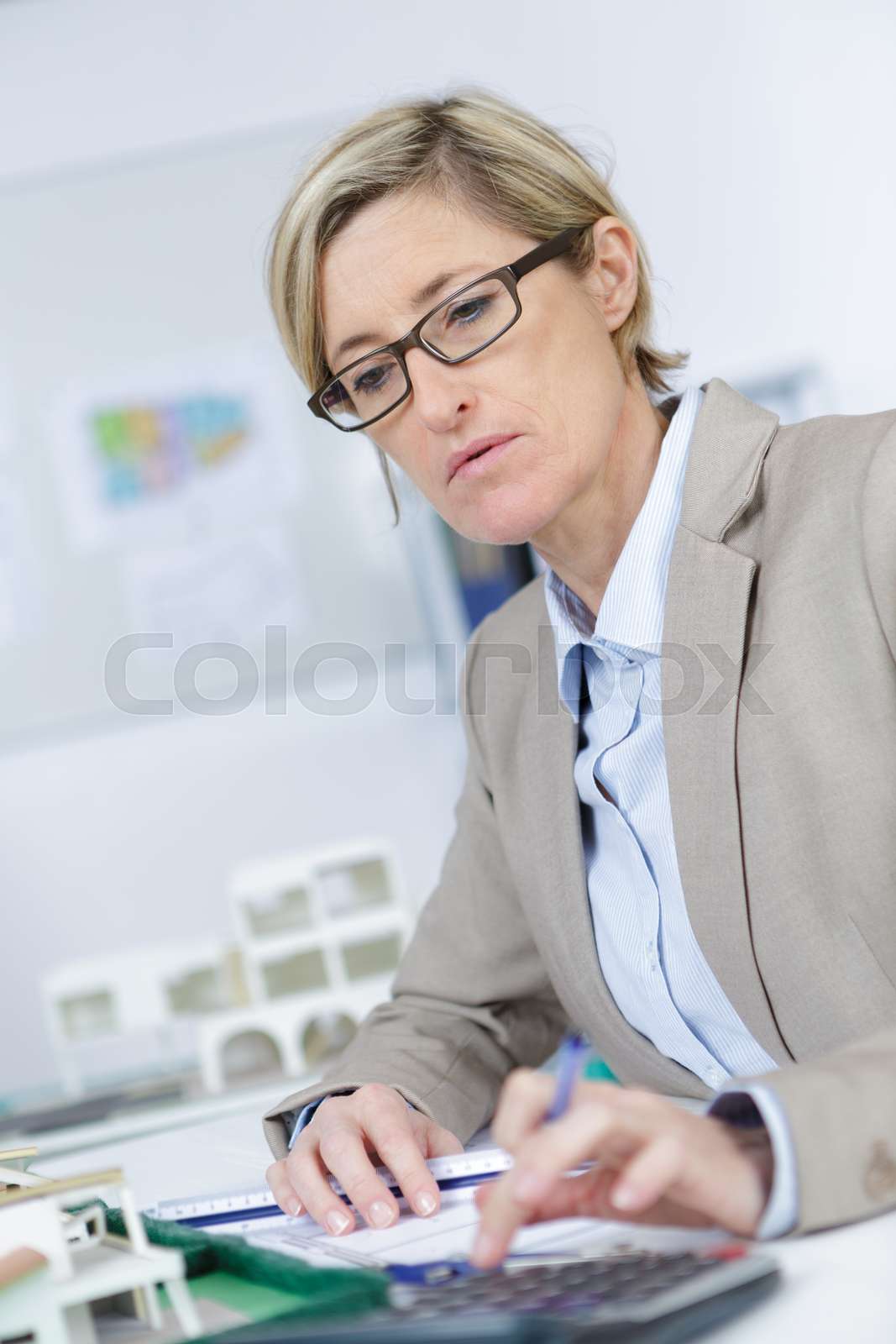woman accountant calculating taxes | Stock image | Colourbox