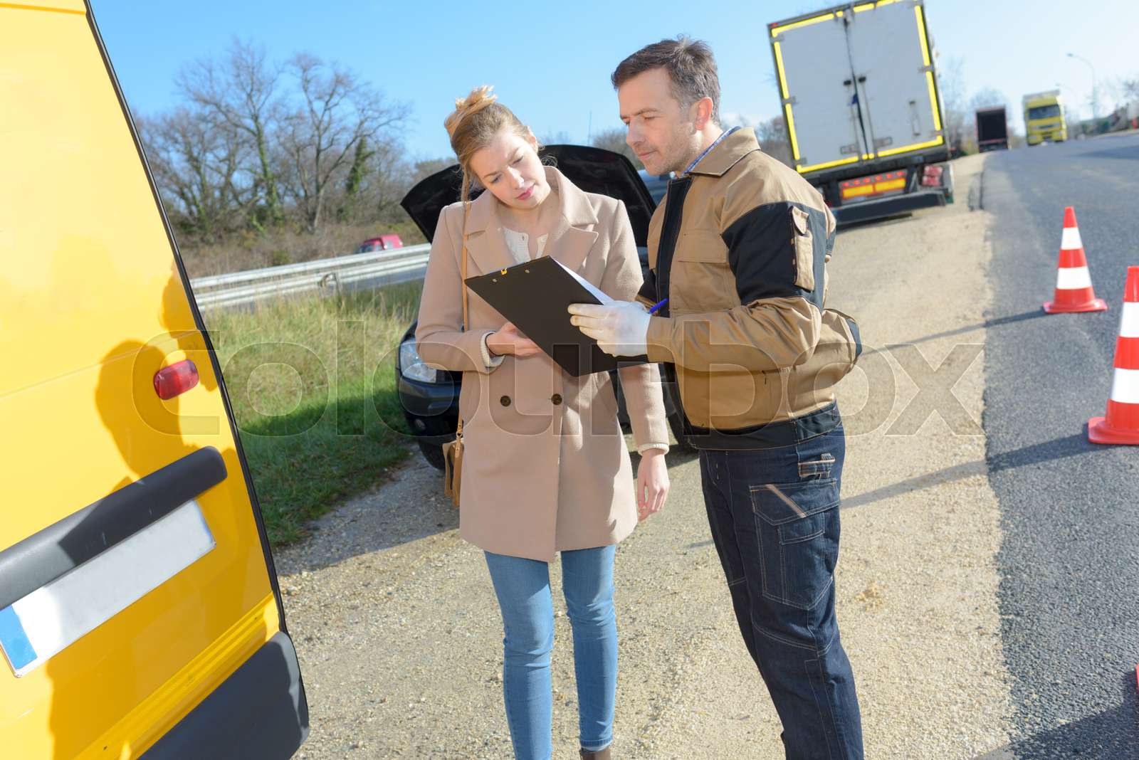 Recovery driver asking customer to sign paperwork | Stock image | Colourbox