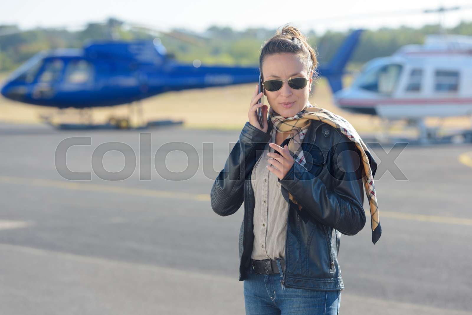female helicopter pilot on the tarmac making a call | Stock image ...
