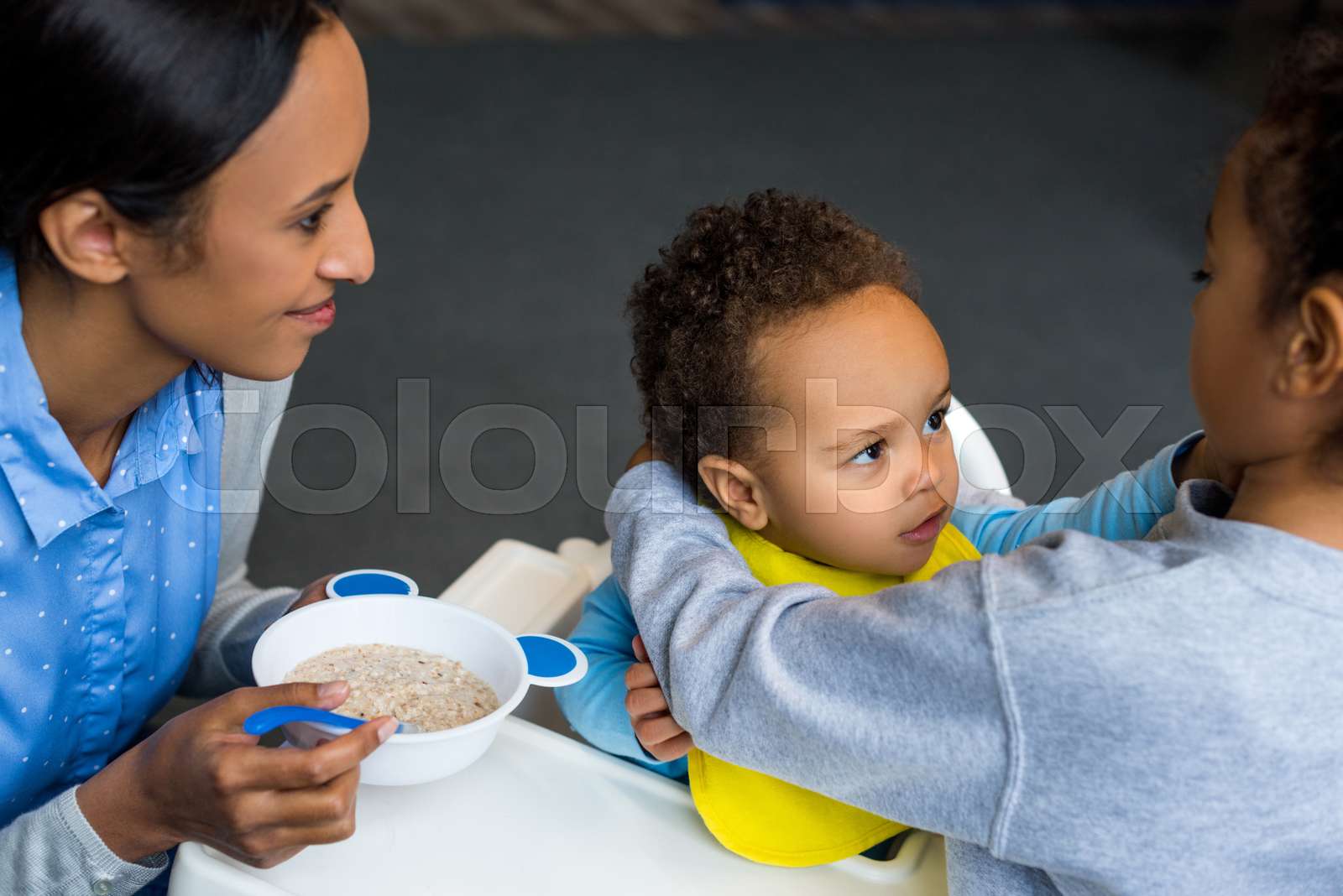 mother and daughter feeding baby | Stock image | Colourbox