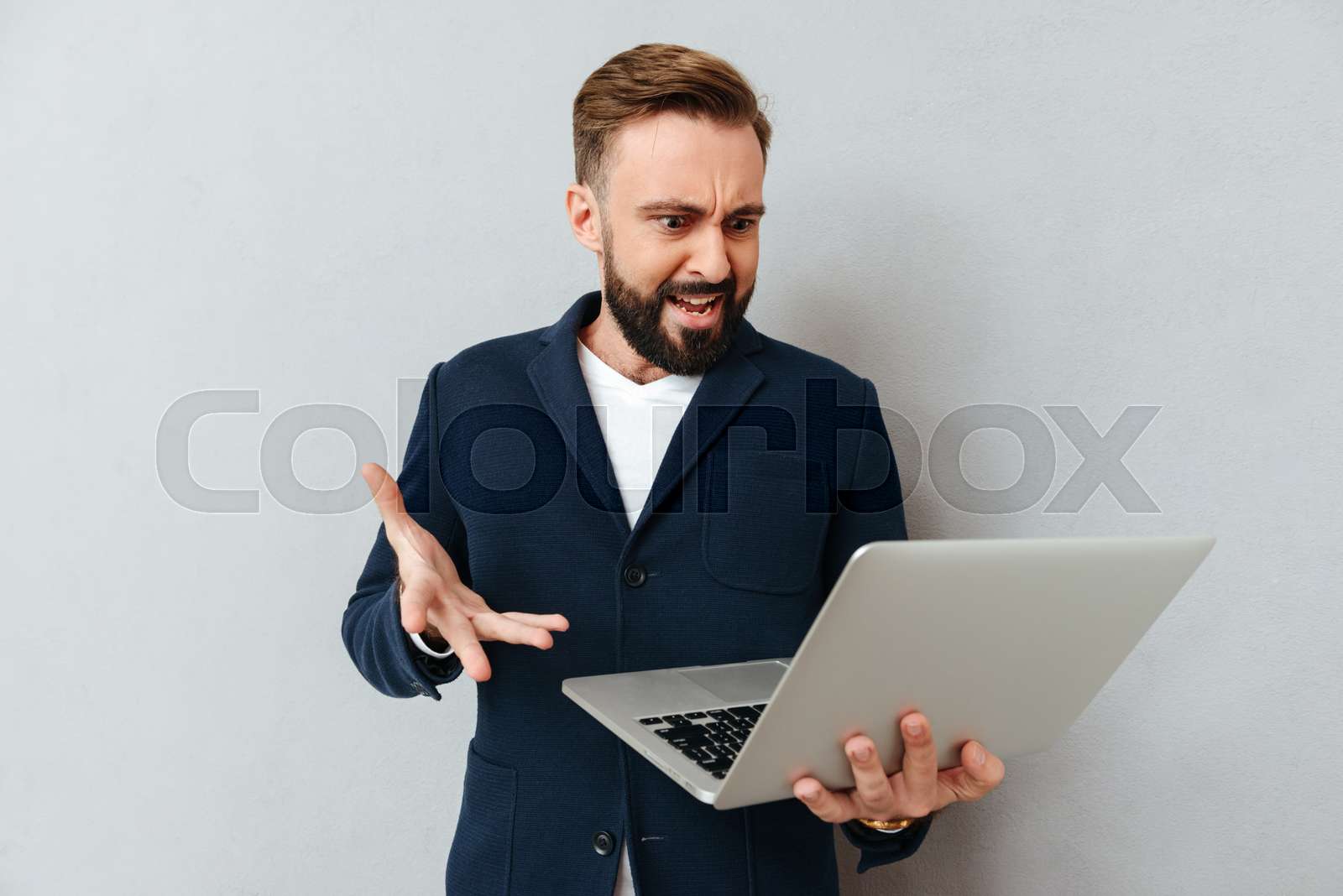 Frown serious man in suit using laptop isolated | Stock image | Colourbox