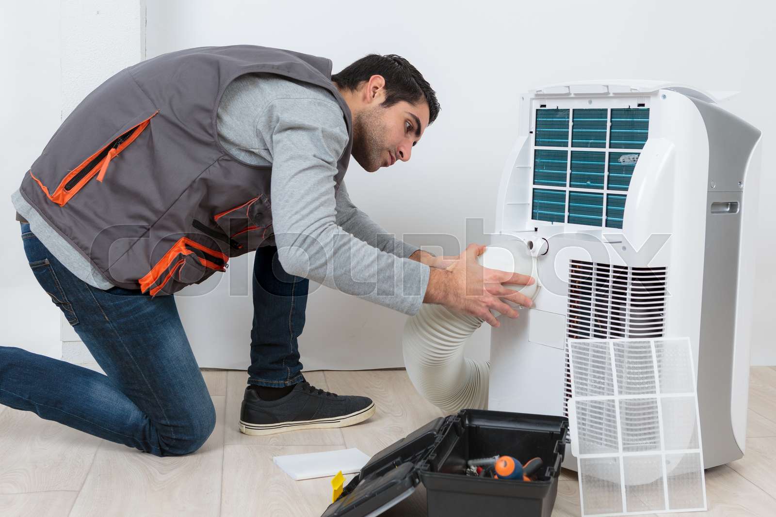 Man working on air conditioning unit | Stock image | Colourbox