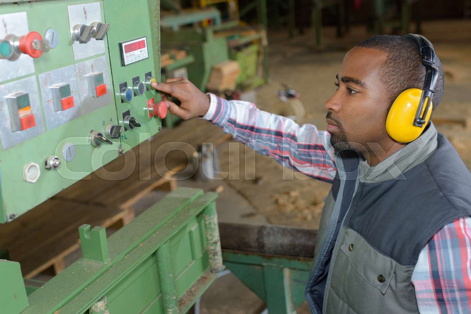 Man controlling industrial machine | Stock image | Colourbox