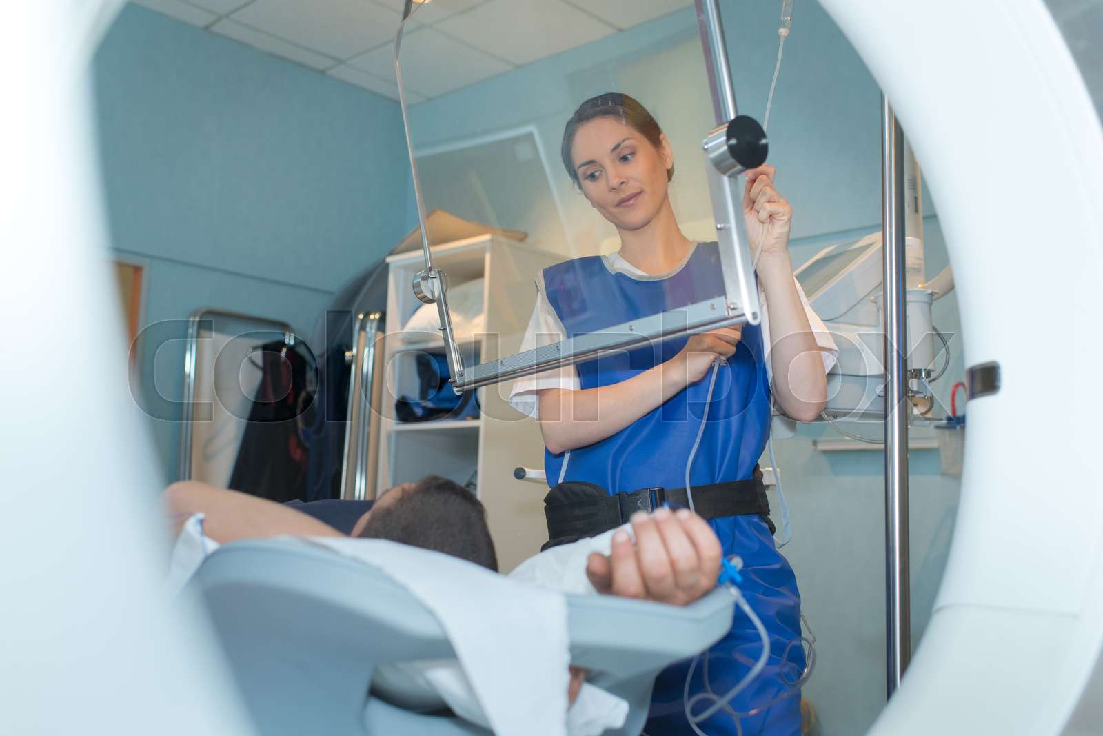 radiologist positioning glass screen beside patient | Stock image ...