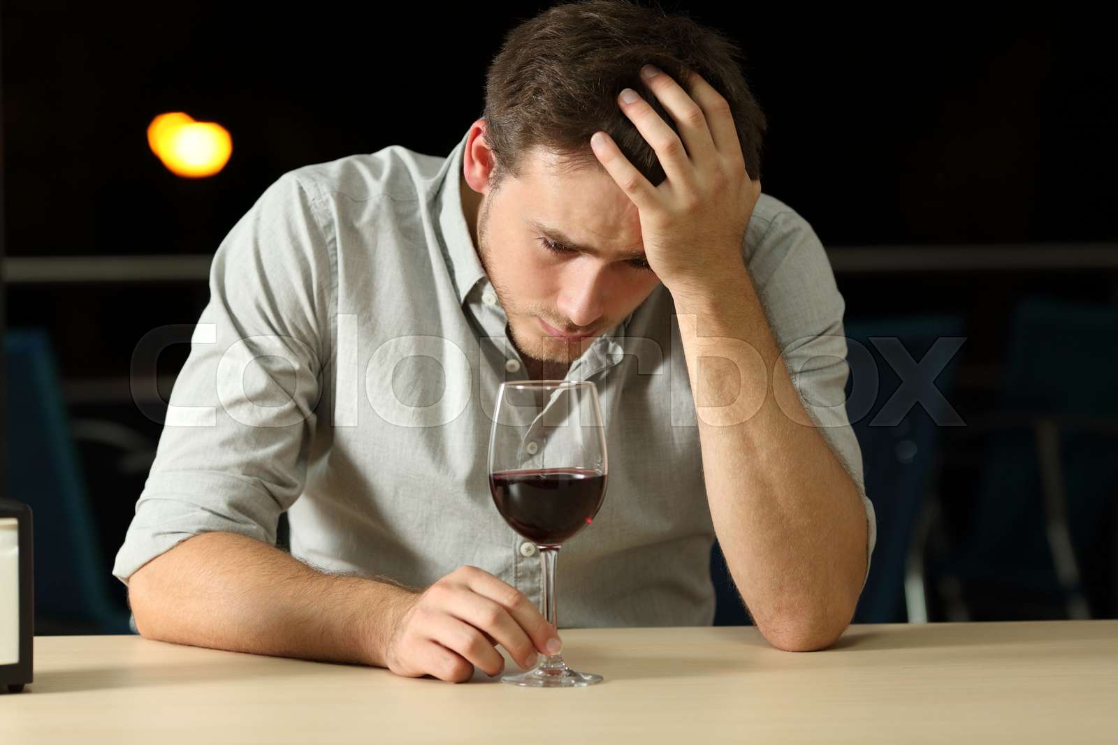 Sad man drinking wine in a bar | Stock image | Colourbox