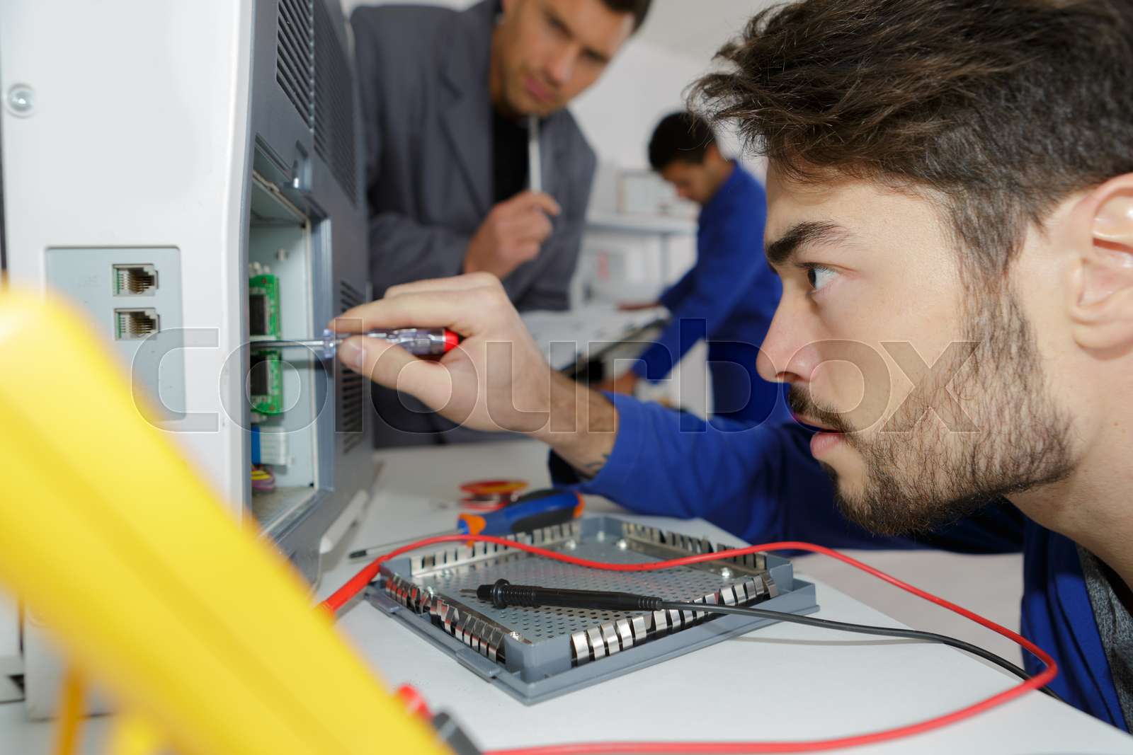 engineer training male apprentice on cnc machine | Stock image | Colourbox