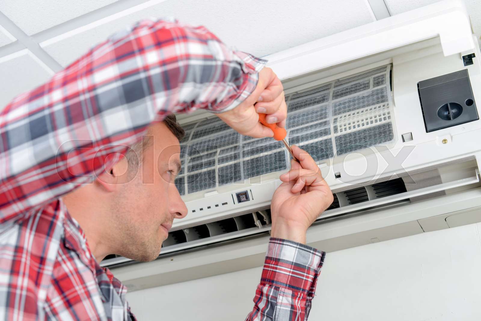 man working on air conditioning unit | Stock image | Colourbox