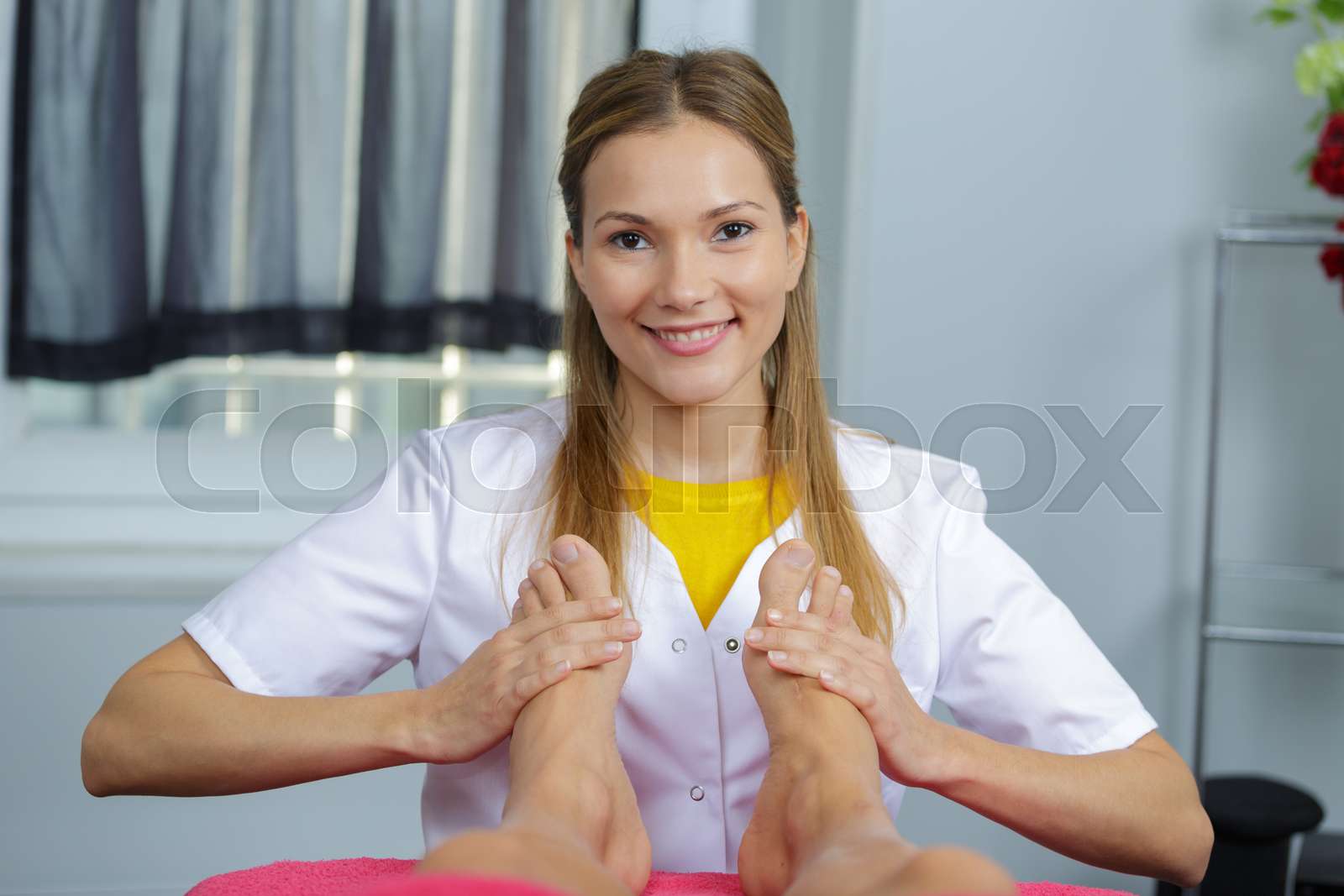 happy spa worker giving a foot massage in salon | Stock image | Colourbox