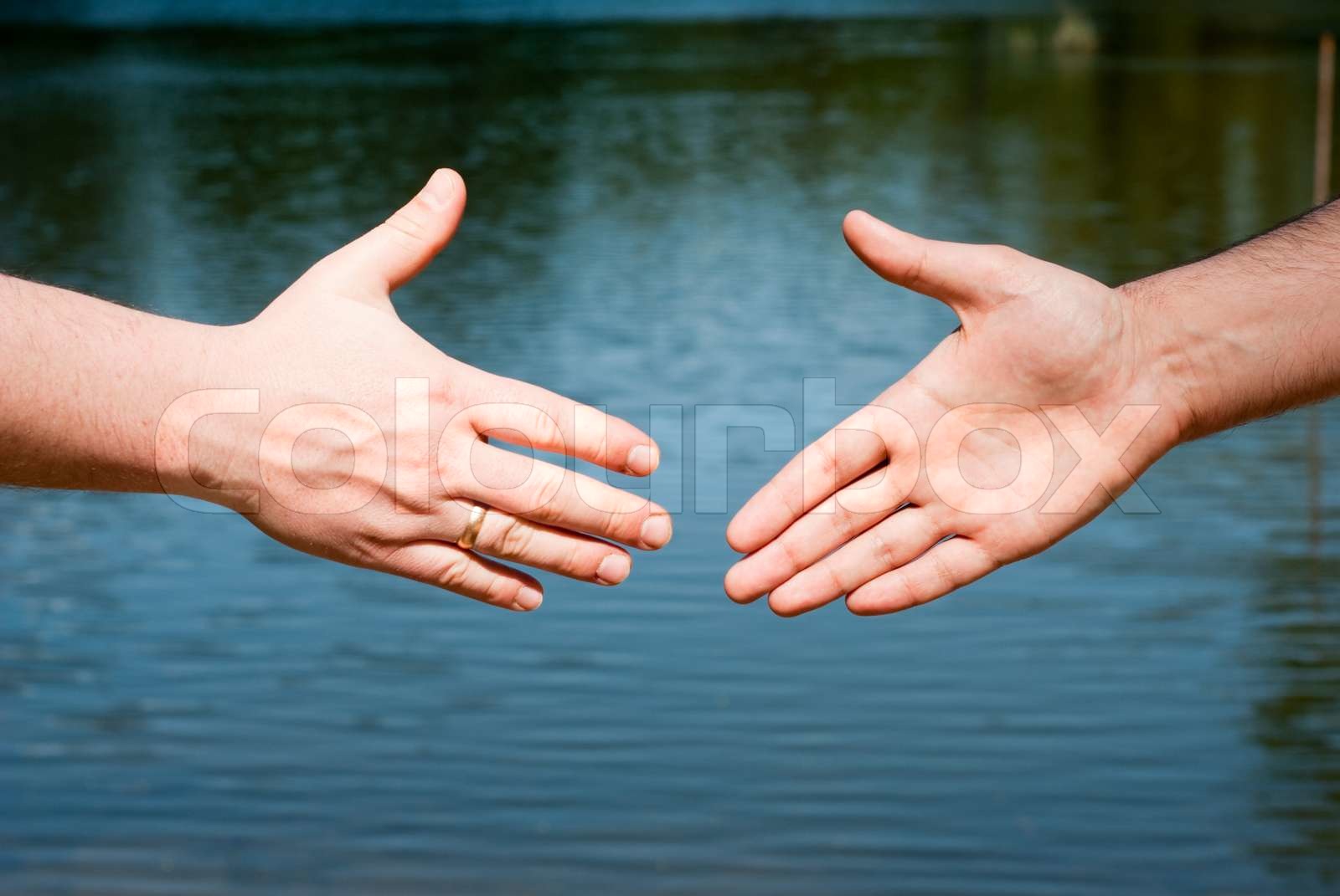 intention to handshake against the water | Stock image | Colourbox