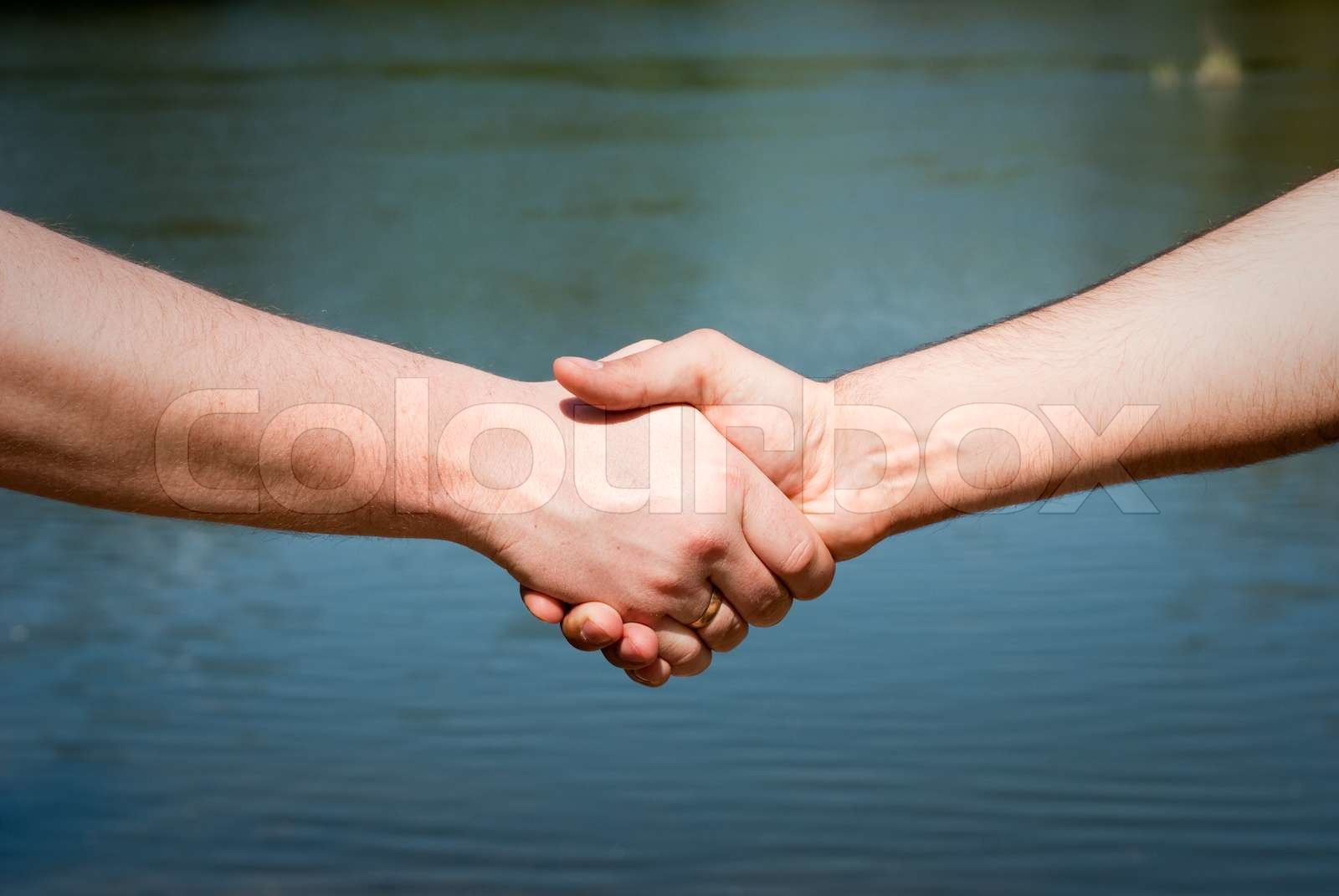 handshake against the deep water | Stock image | Colourbox
