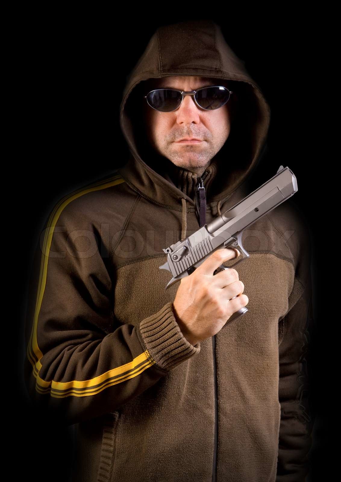 man in a hood with gun | Stock image | Colourbox