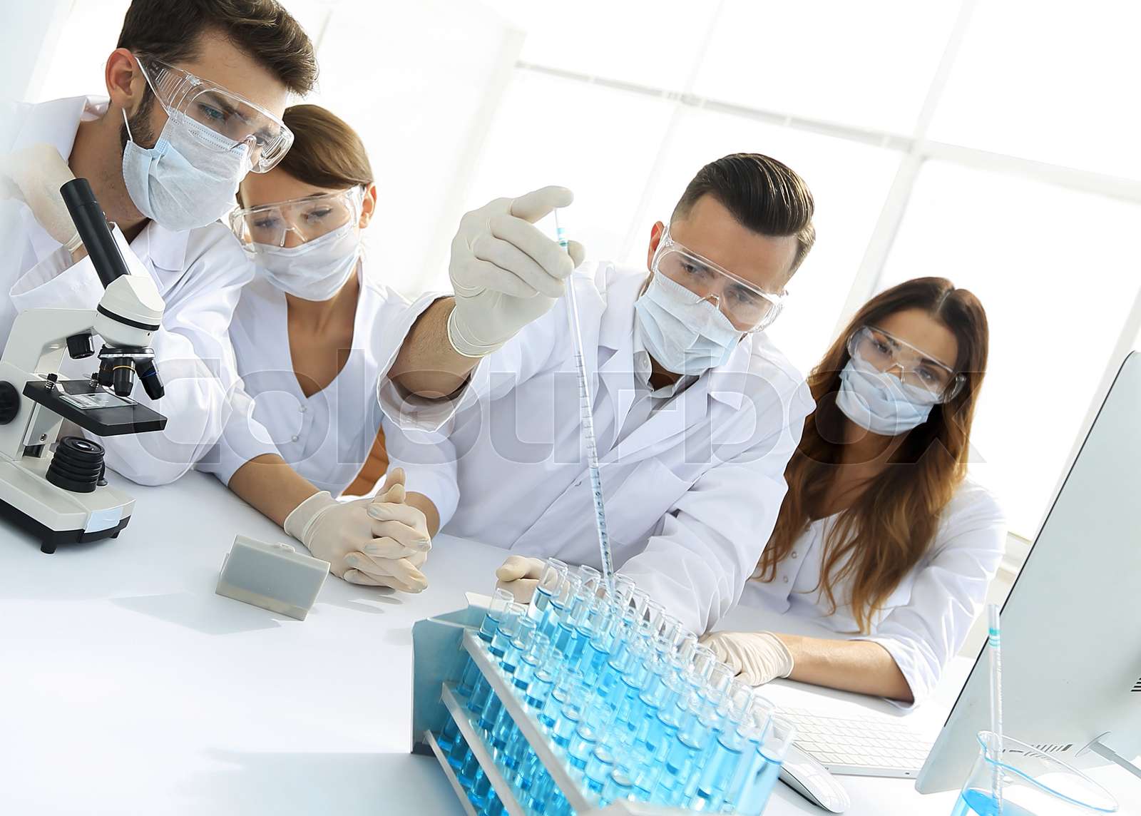 medical doctors are working with test tubes and microscope at the lab ...