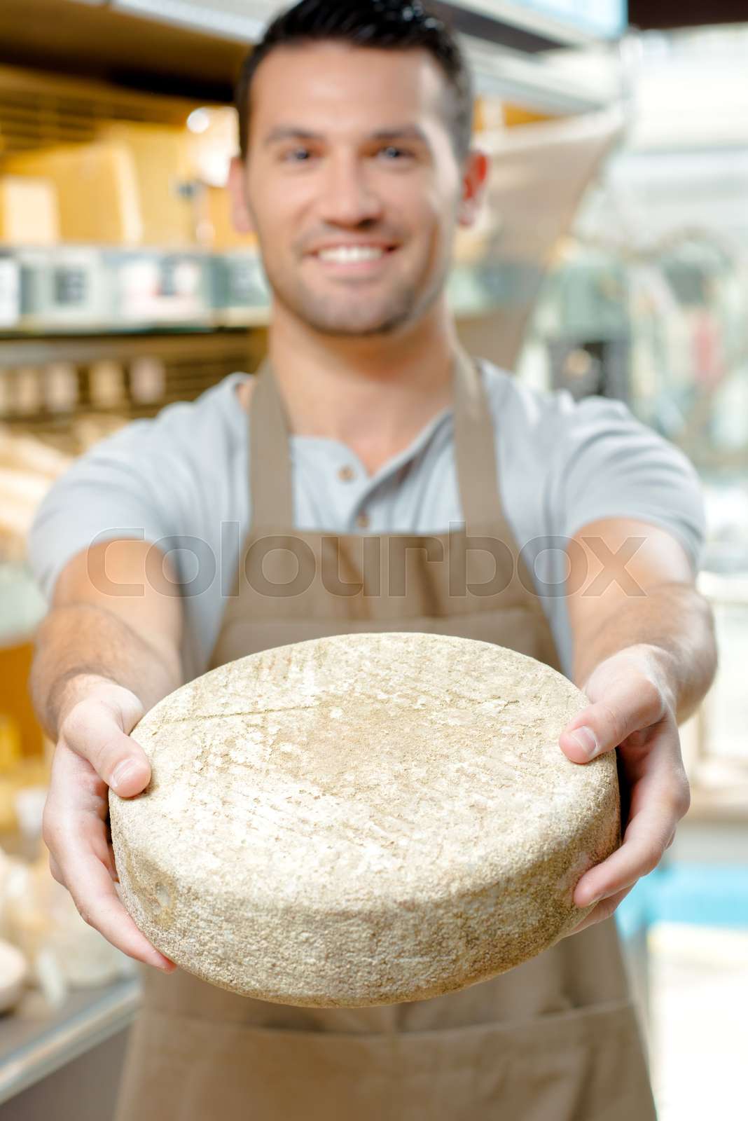 Man holding a wheel of cheese | Stock image | Colourbox