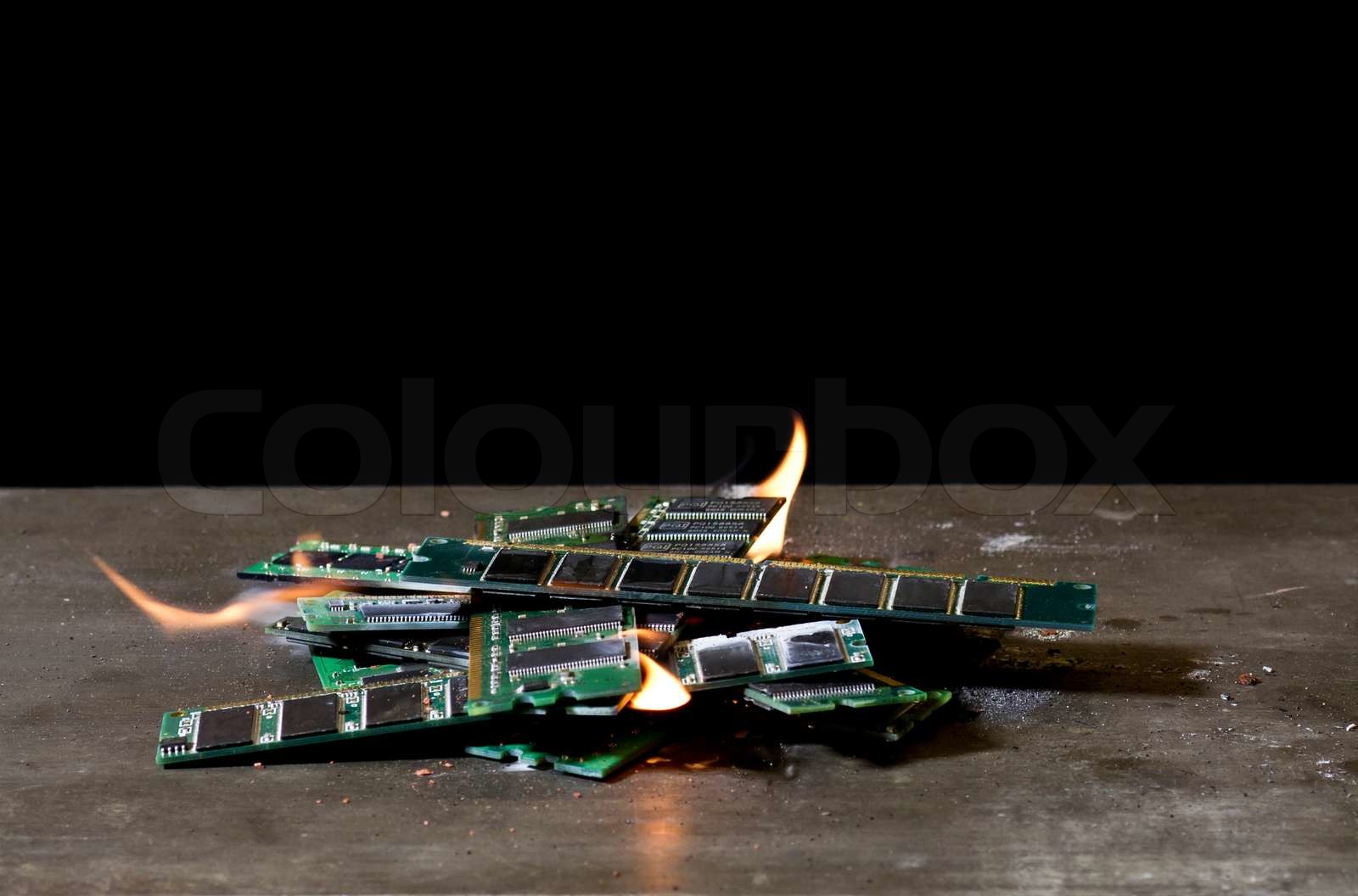 small pile of burning RAM sticks located on metal surface in front of ...