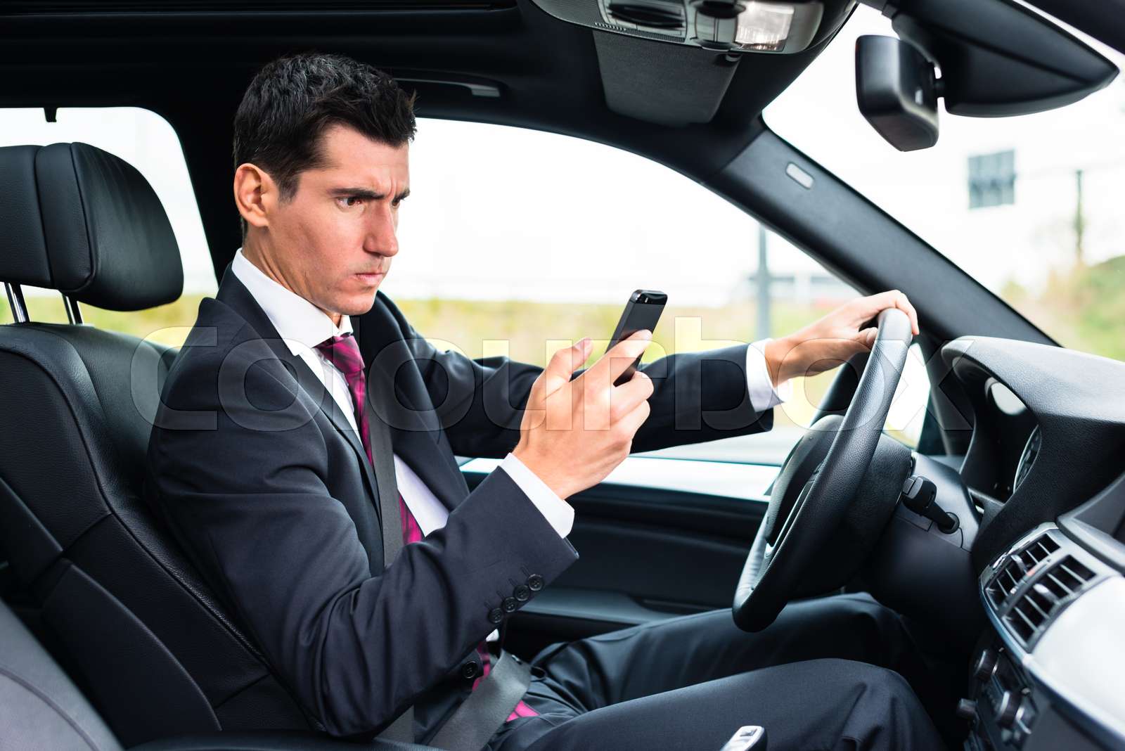 Man texting while driving by car | Stock image | Colourbox