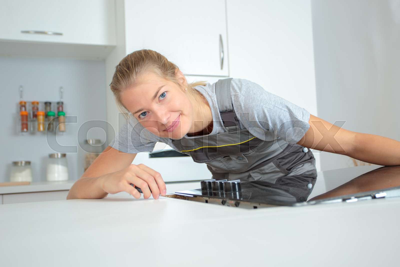 Portrait of lady fitting induction hob | Stock image | Colourbox