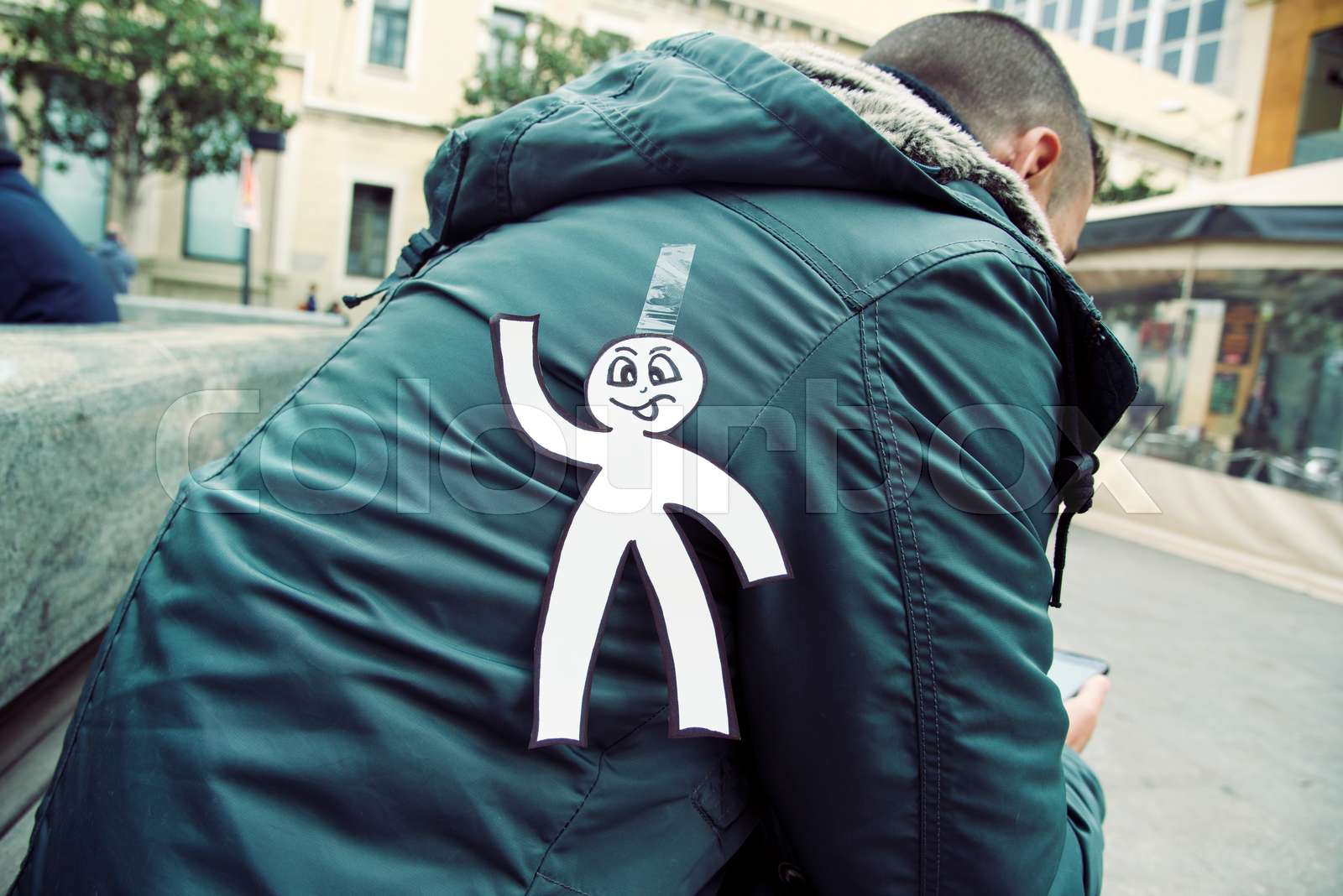 young man with a paper man attached to his back | Stock image | Colourbox
