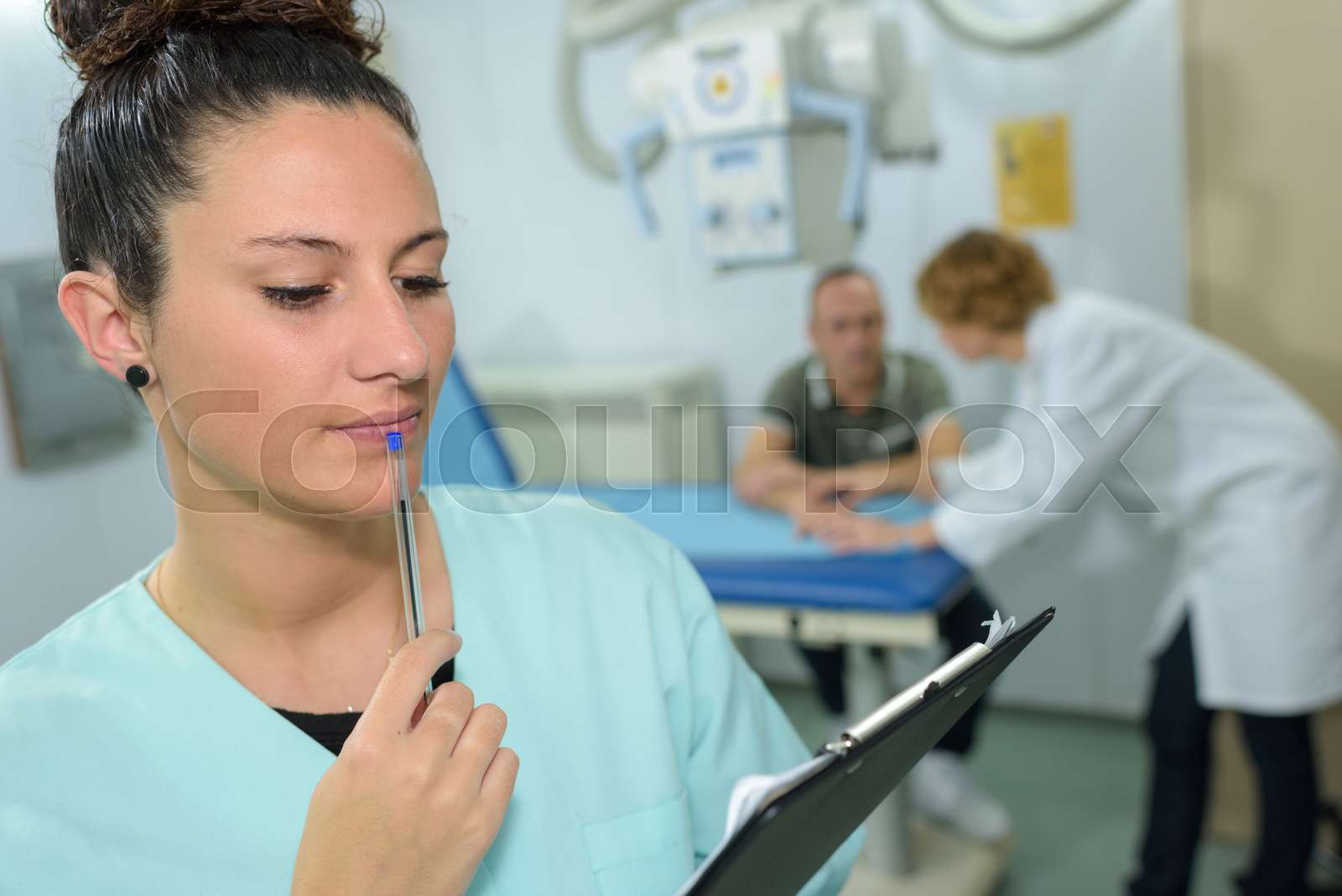 nurse checking a medical report in hospital room | Stock image | Colourbox