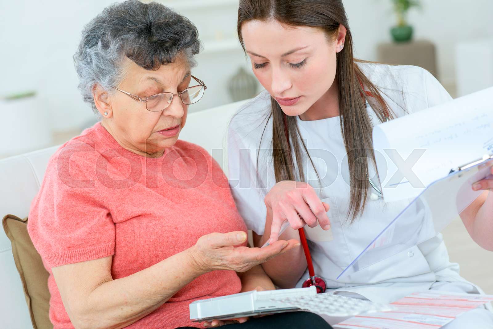 Doctor helping patient with medication | Stock image | Colourbox