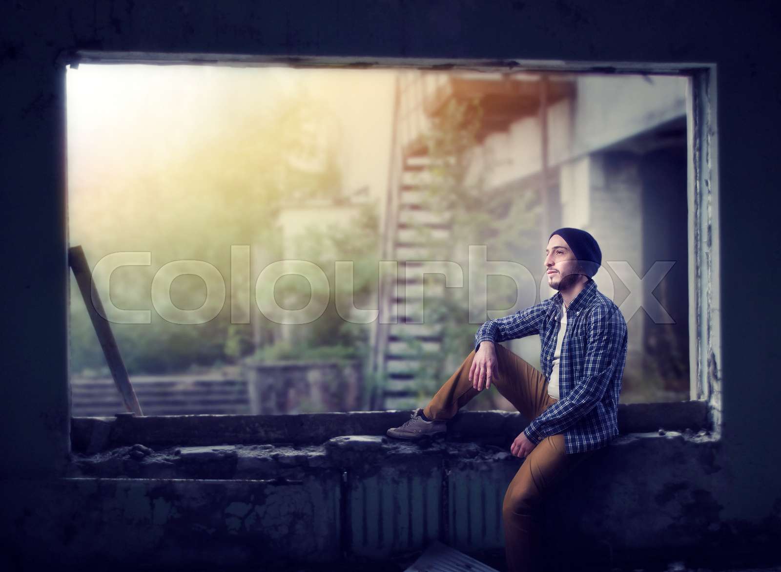 Stalker sitting on the window, abandoned city | Stock image | Colourbox