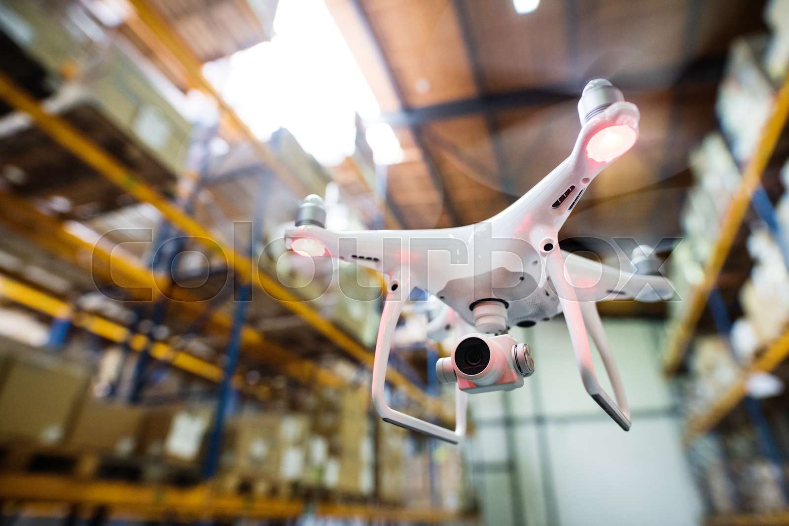 White drone flying inside the warehouse. | Stock image | Colourbox