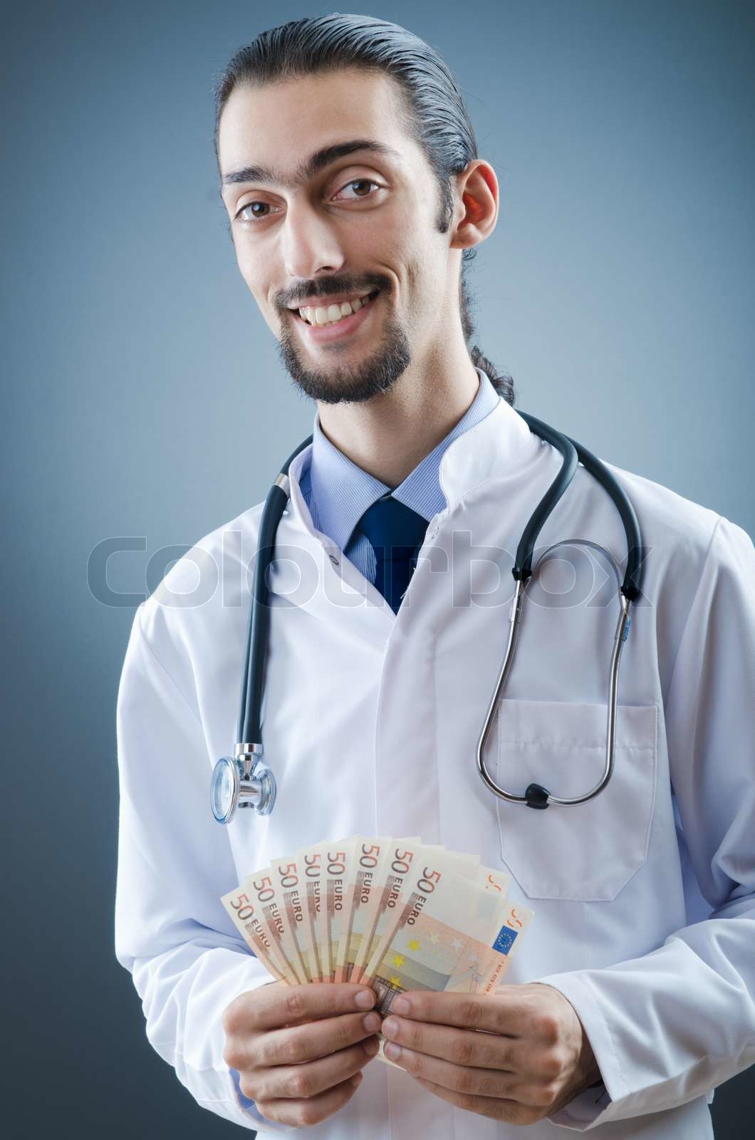 Doctor with money in studio | Stock image | Colourbox