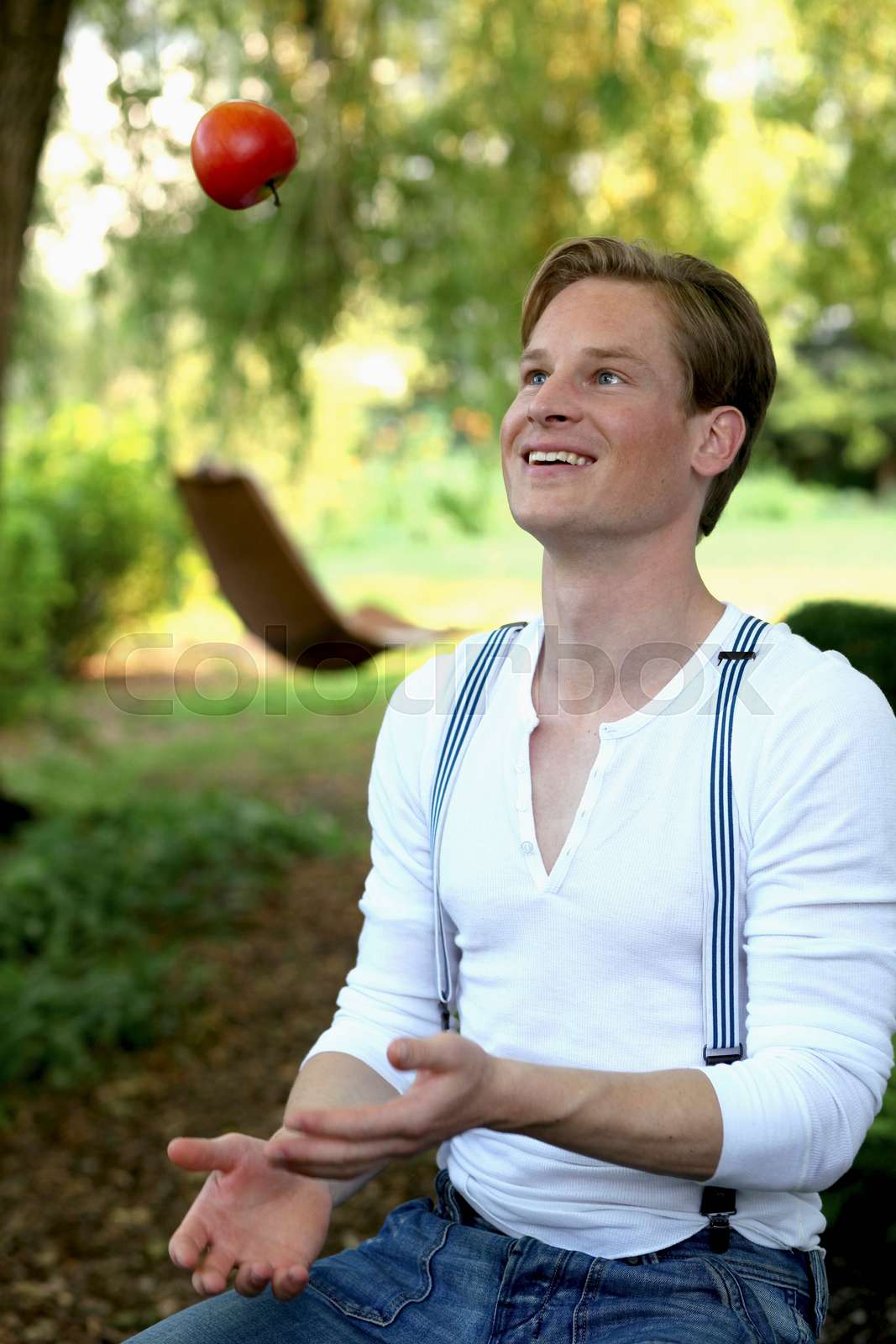 Young man throwing an apple | Stock image | Colourbox