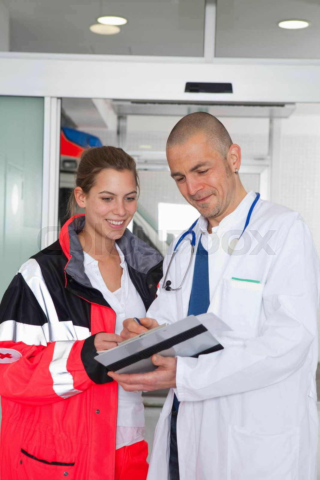 Paramedic and doctor examining file | Stock image | Colourbox