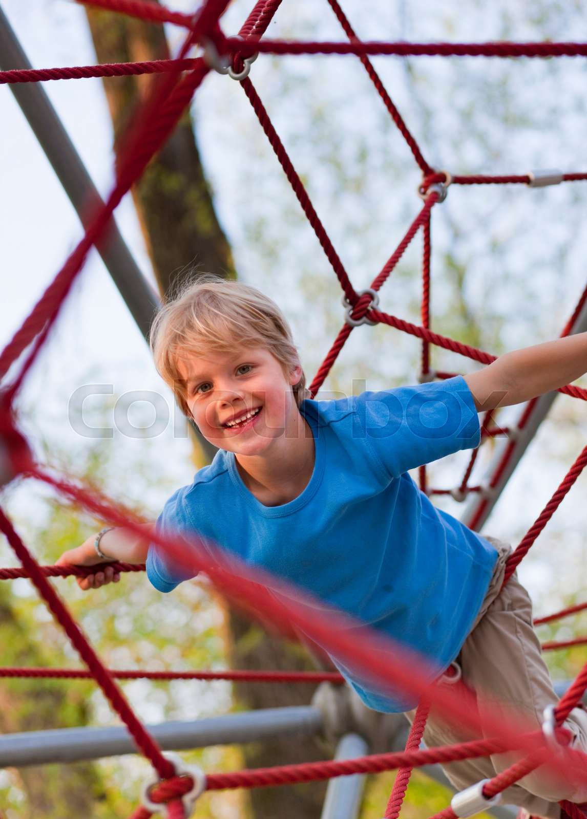 Boy climbing at playground | Stock image | Colourbox