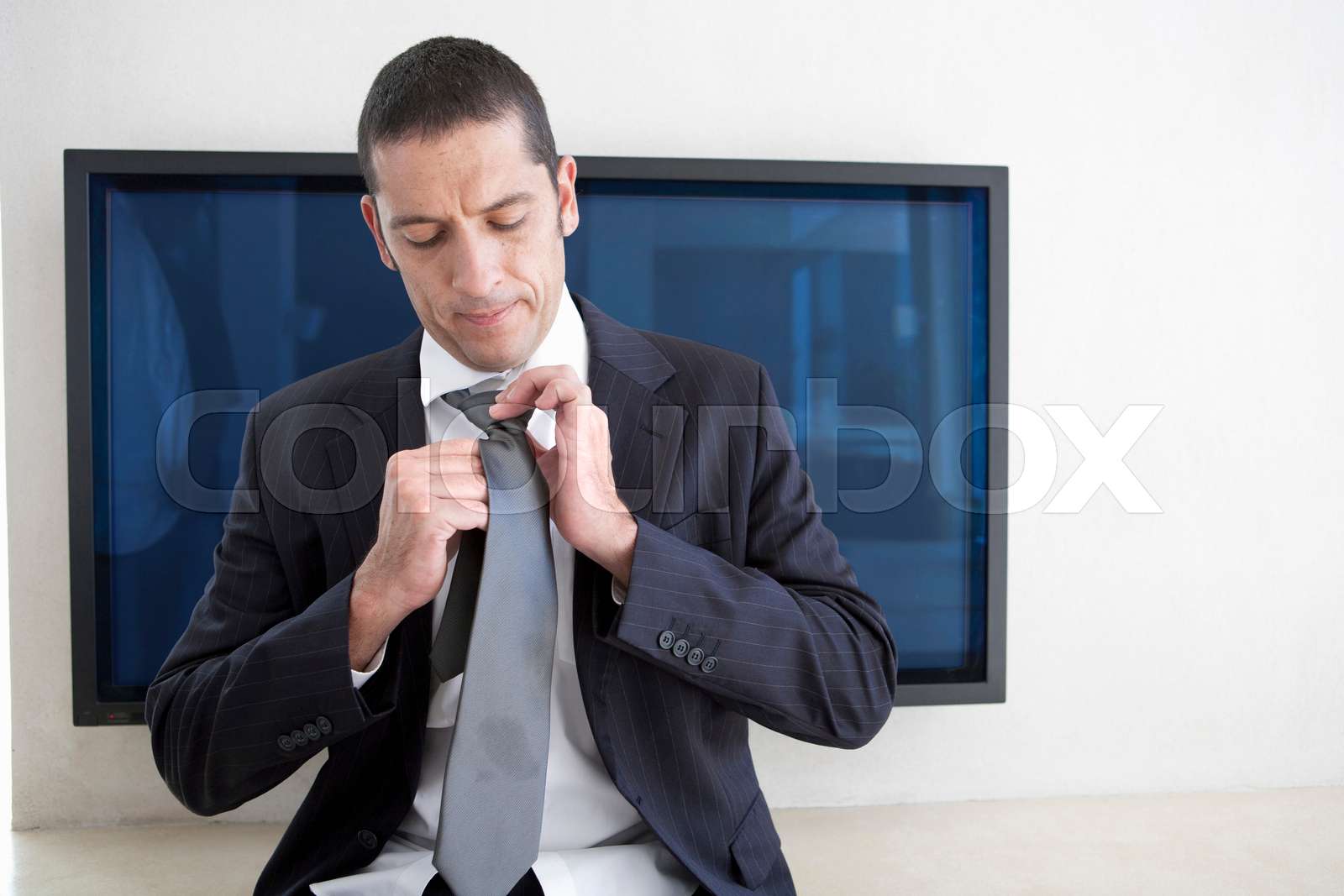 Businessman tying his tie in office | Stock image | Colourbox