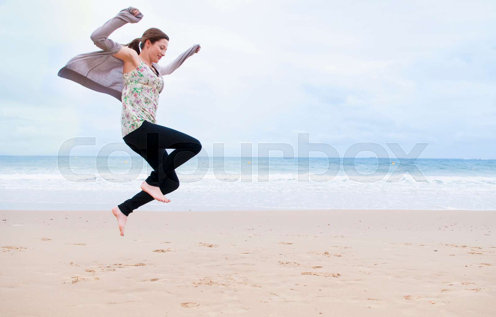 Woman jumping on beach | Stock image | Colourbox