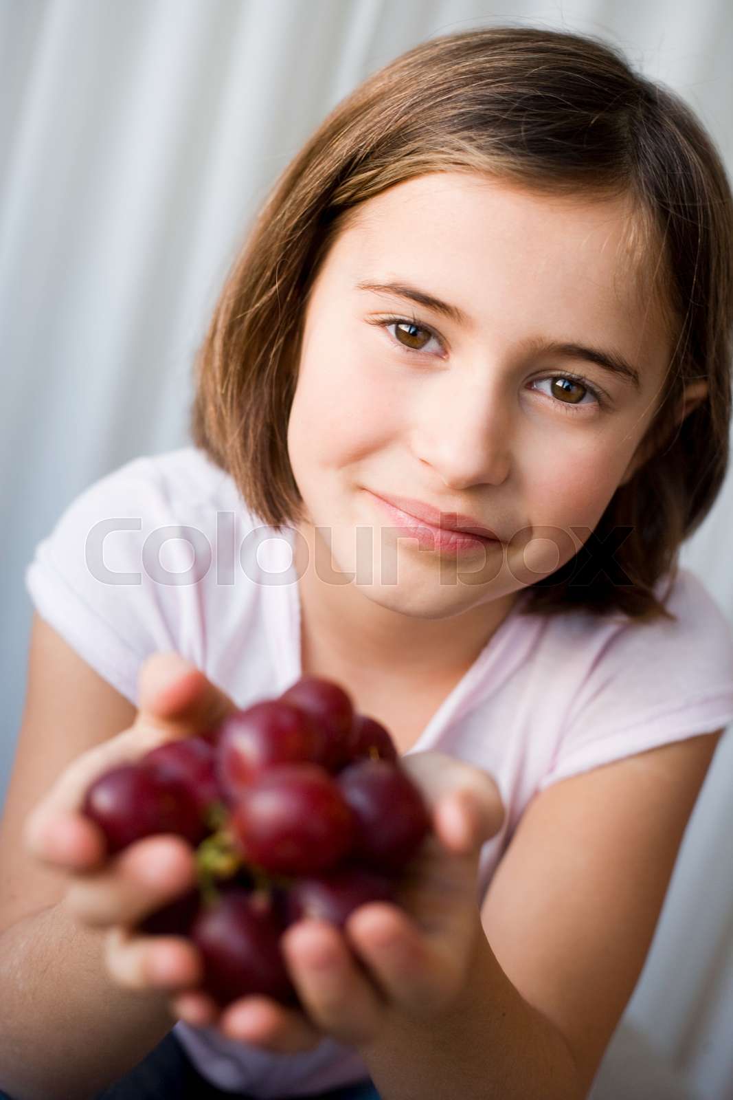 Girl offering grapes | Stock image | Colourbox