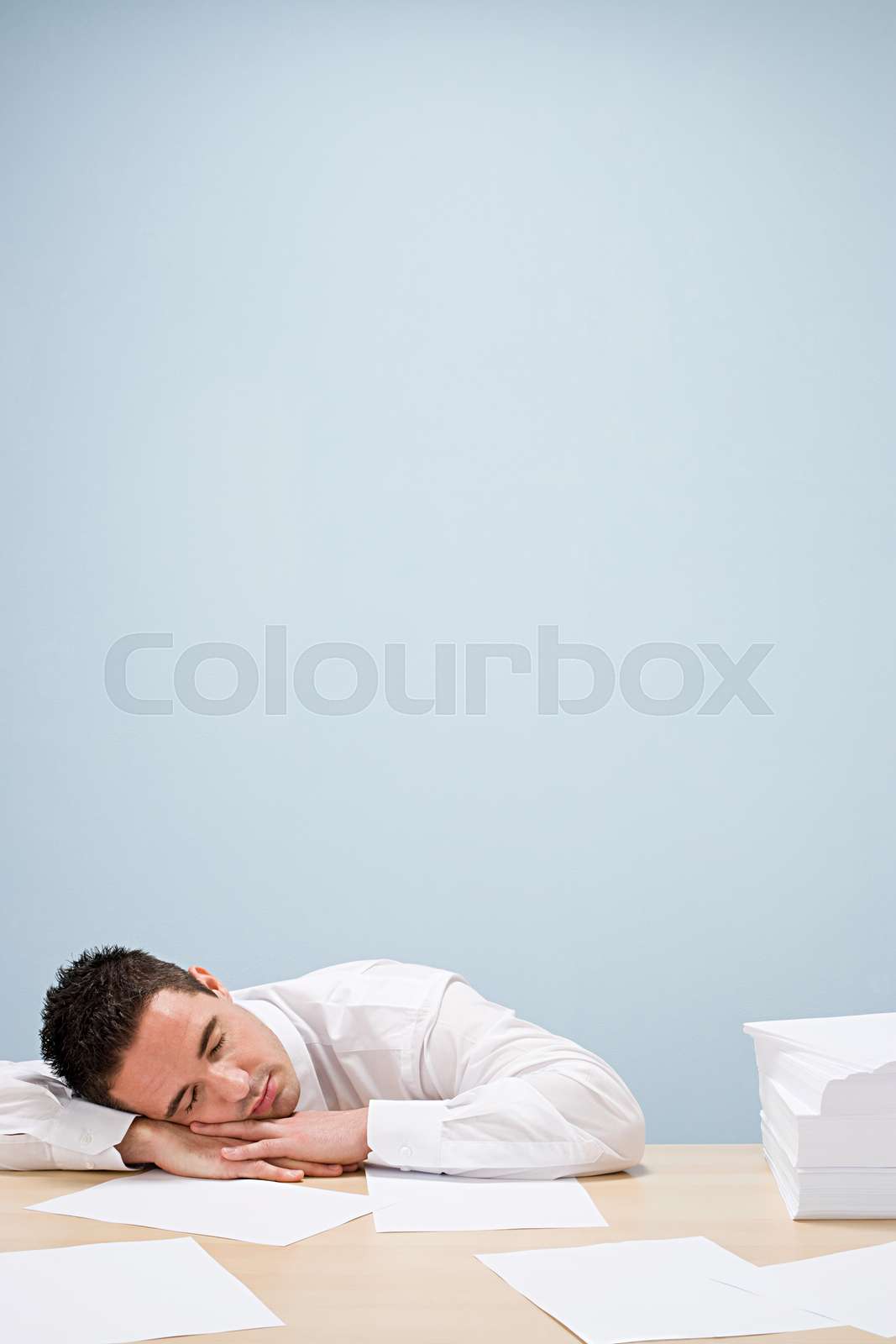 Office worker sleeping on desk | Stock image | Colourbox