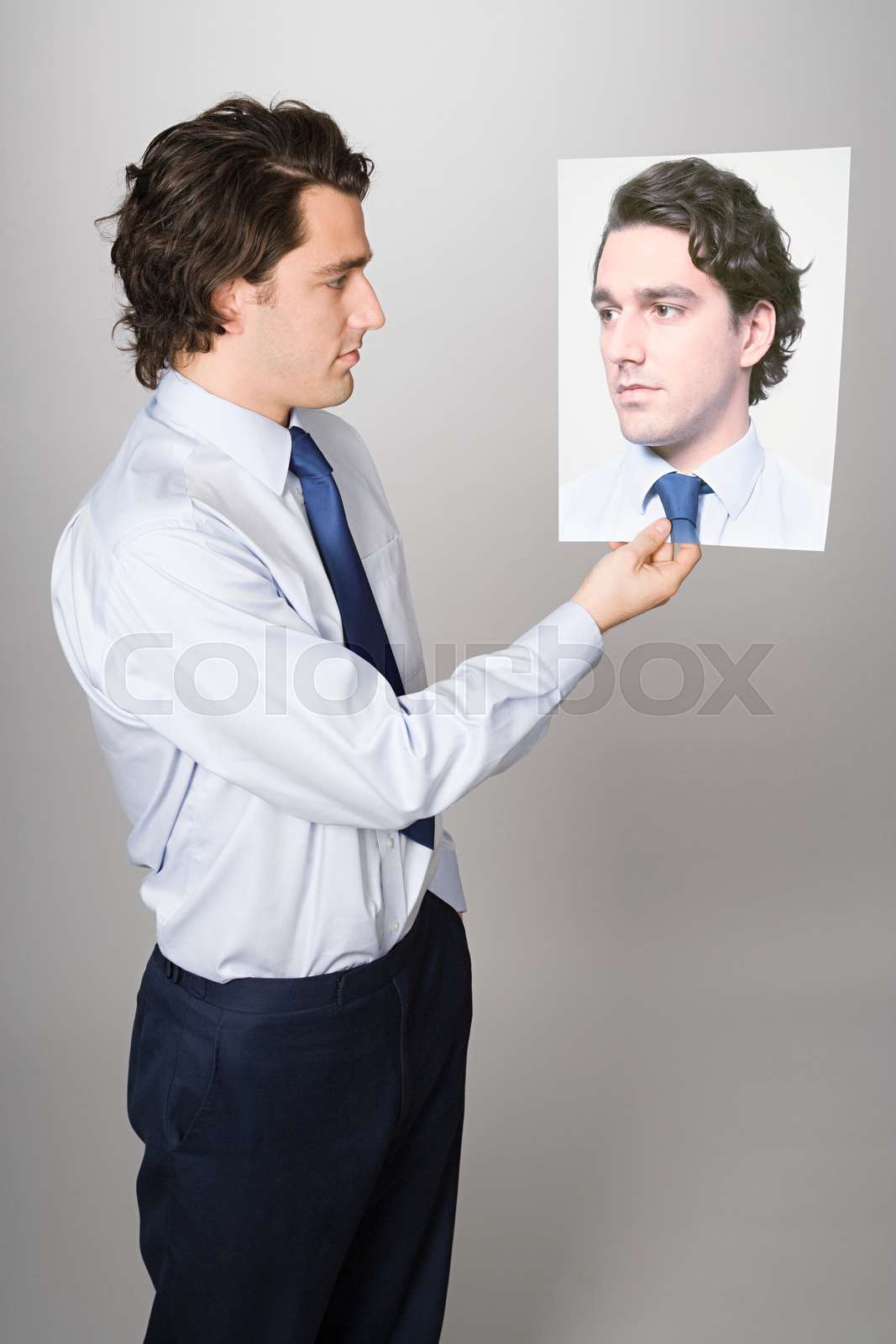 Portrait of a man holding a photograph of himself | Stock image | Colourbox