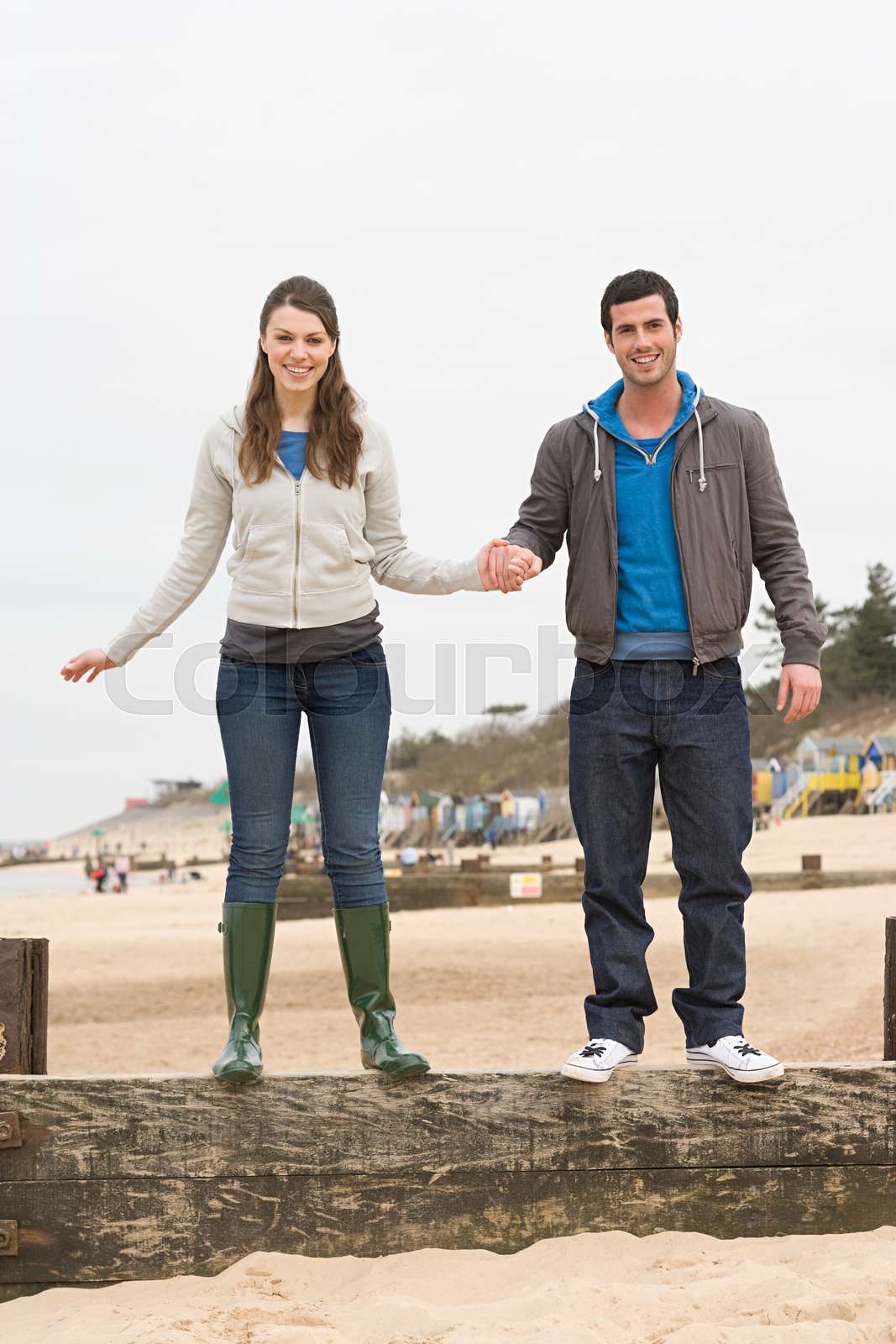 Couple standing on a fence at beach | Stock image | Colourbox