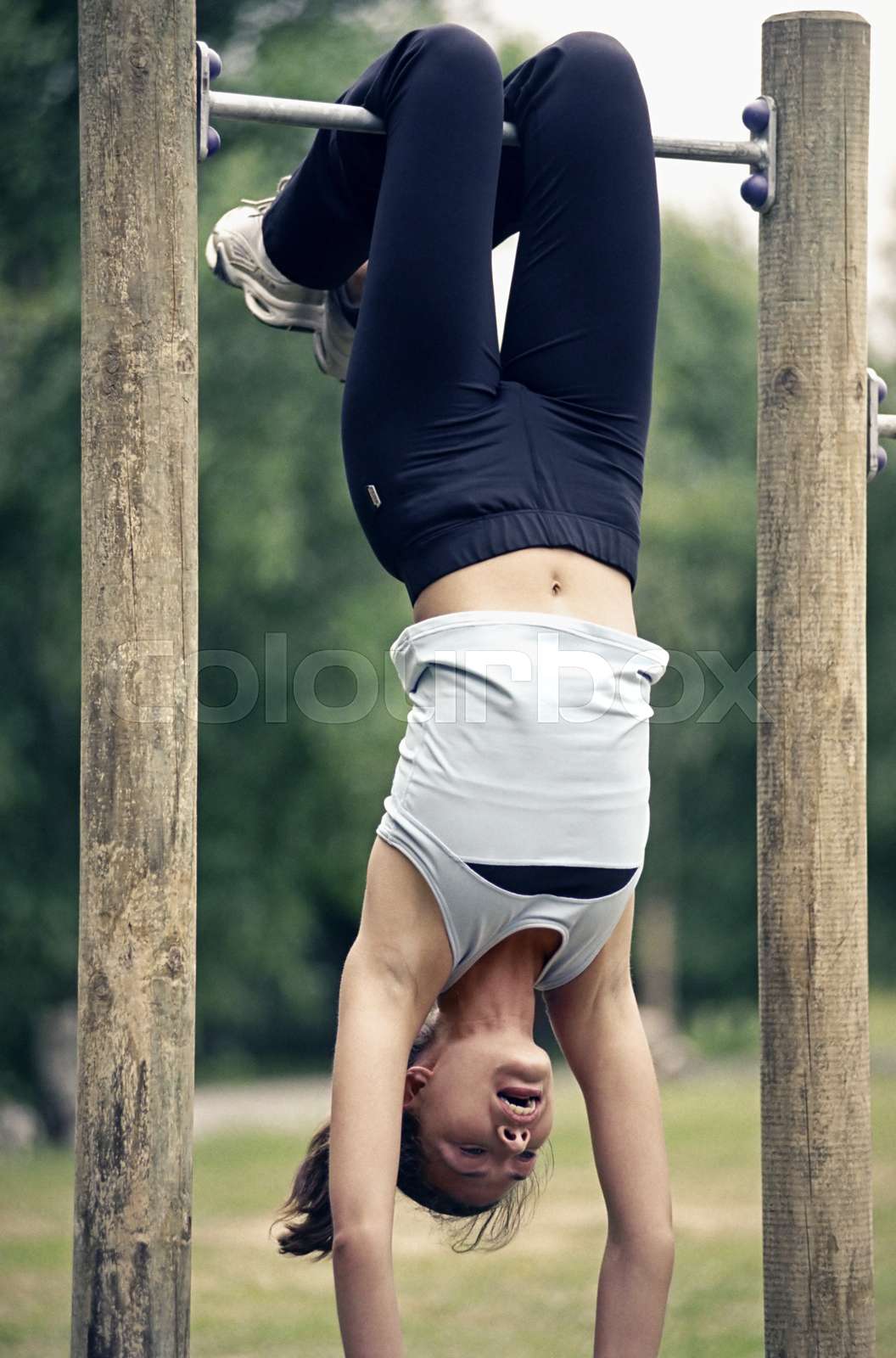 Woman hanging from bar | Stock image | Colourbox