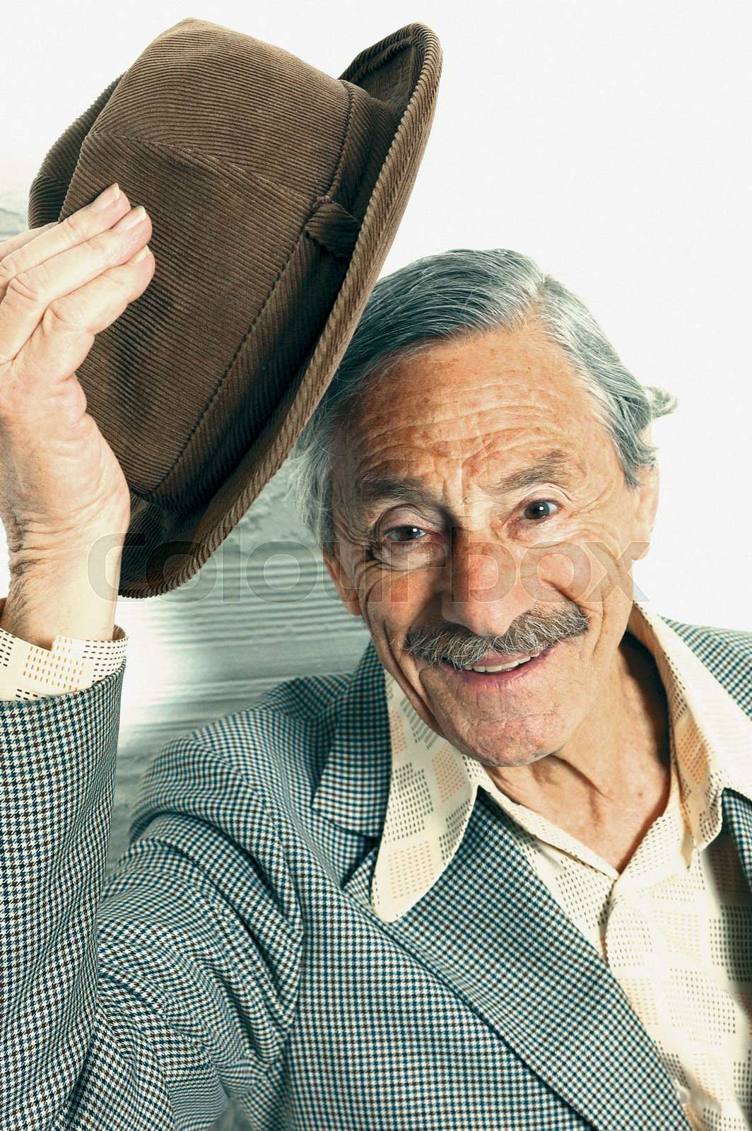Old man taking hat off | Stock image | Colourbox
