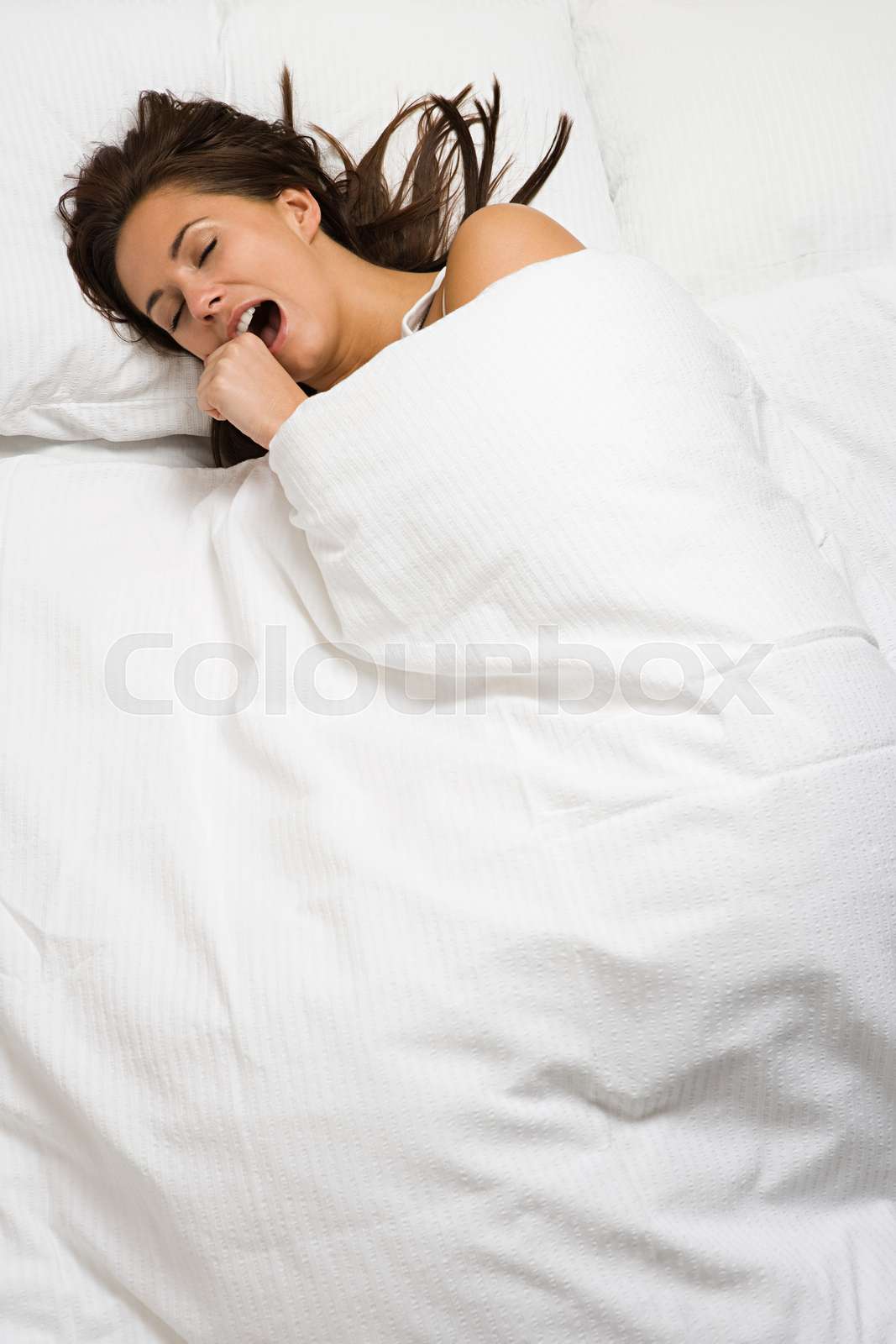Woman yawning in bed | Stock image | Colourbox
