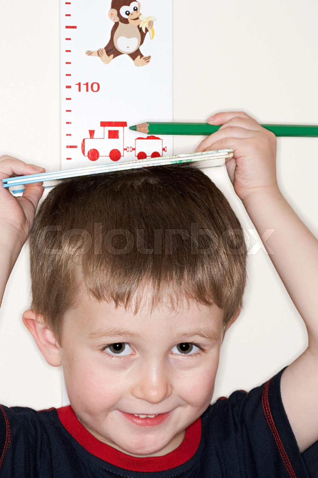 Boy measuring his height | Stock image | Colourbox