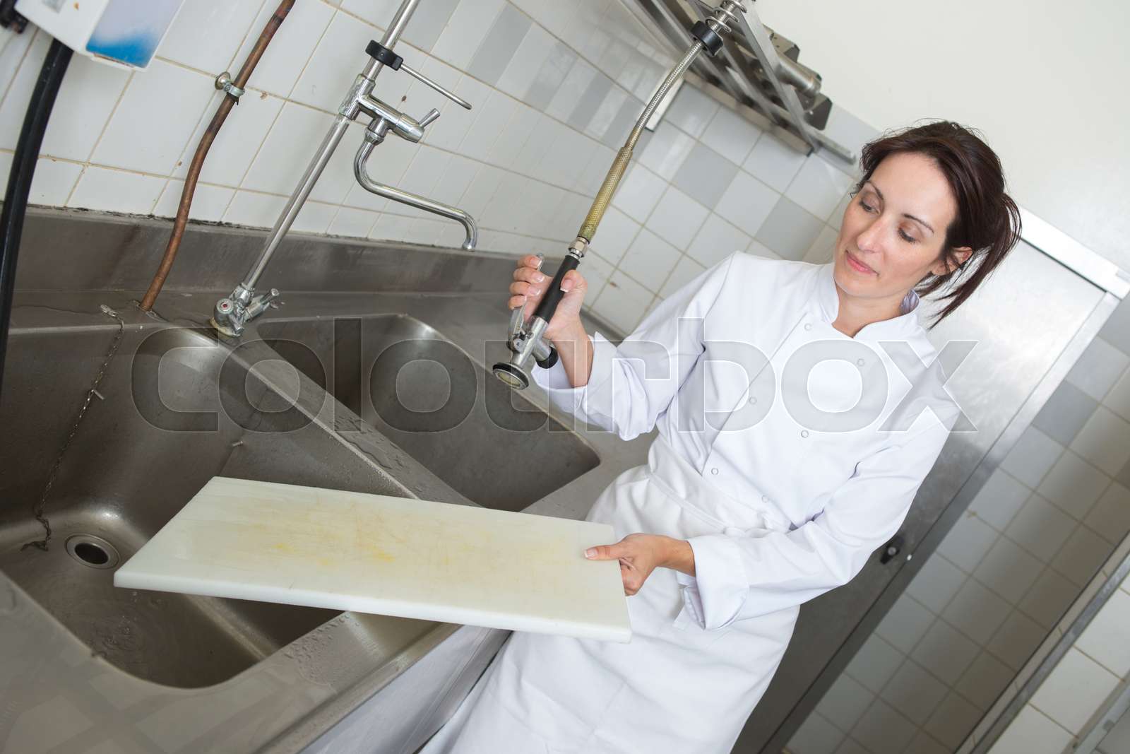 happy female clerk washing the dishes in restaurant kitchen | Stock ...
