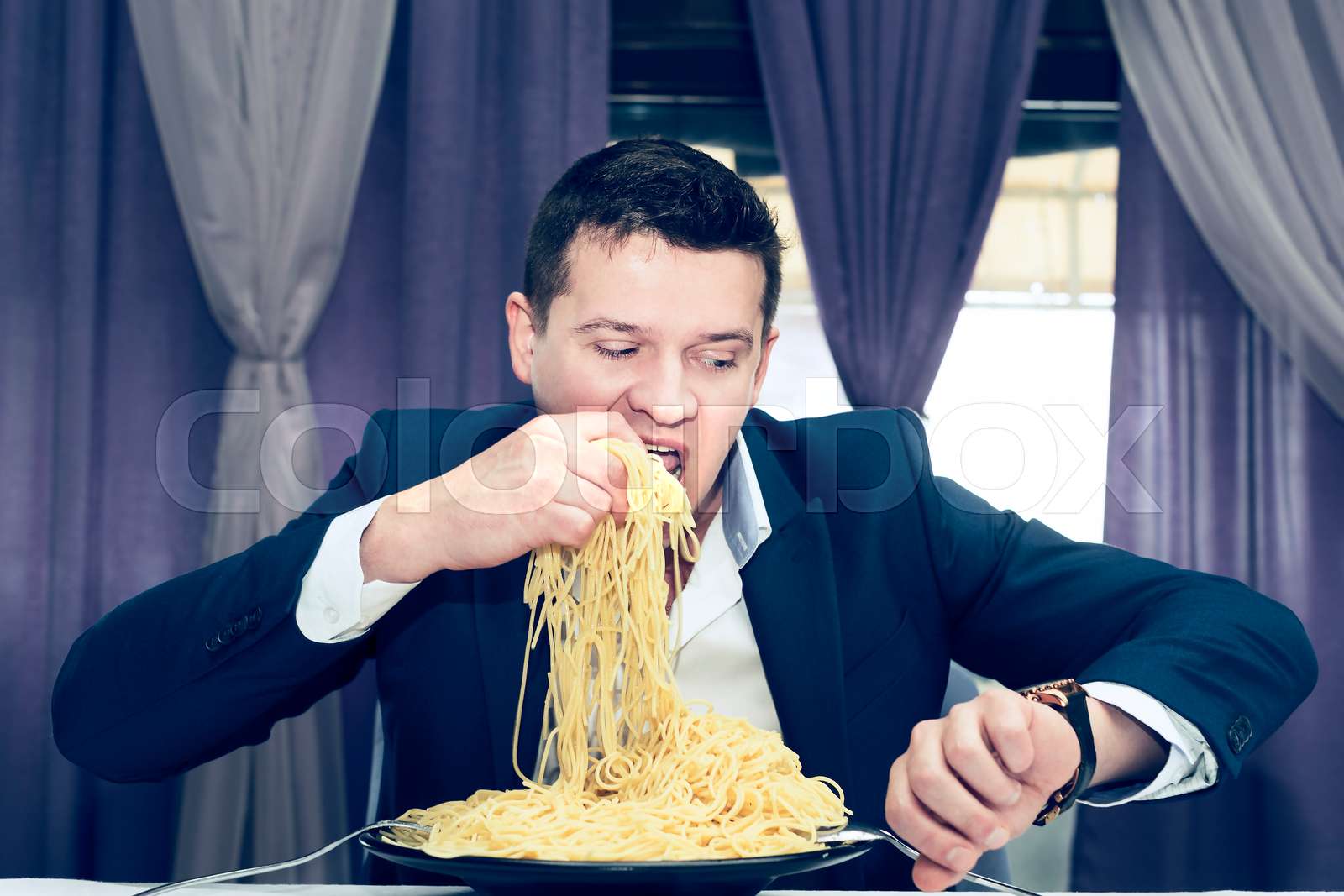 Man eating a large portion of pasta in a restaurant | Stock image ...