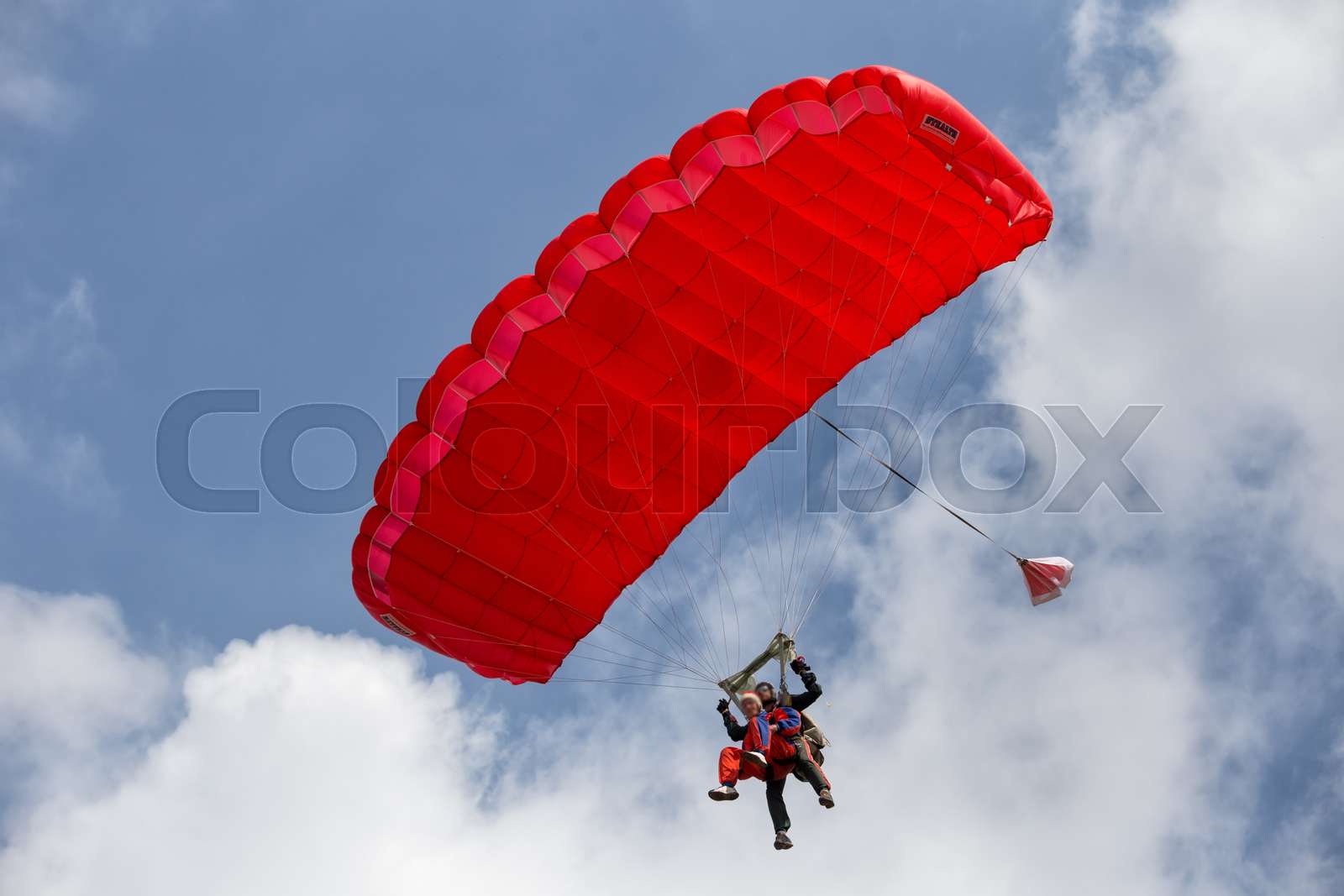 Tandem paratroopers descends on a red parachute | Stock image | Colourbox