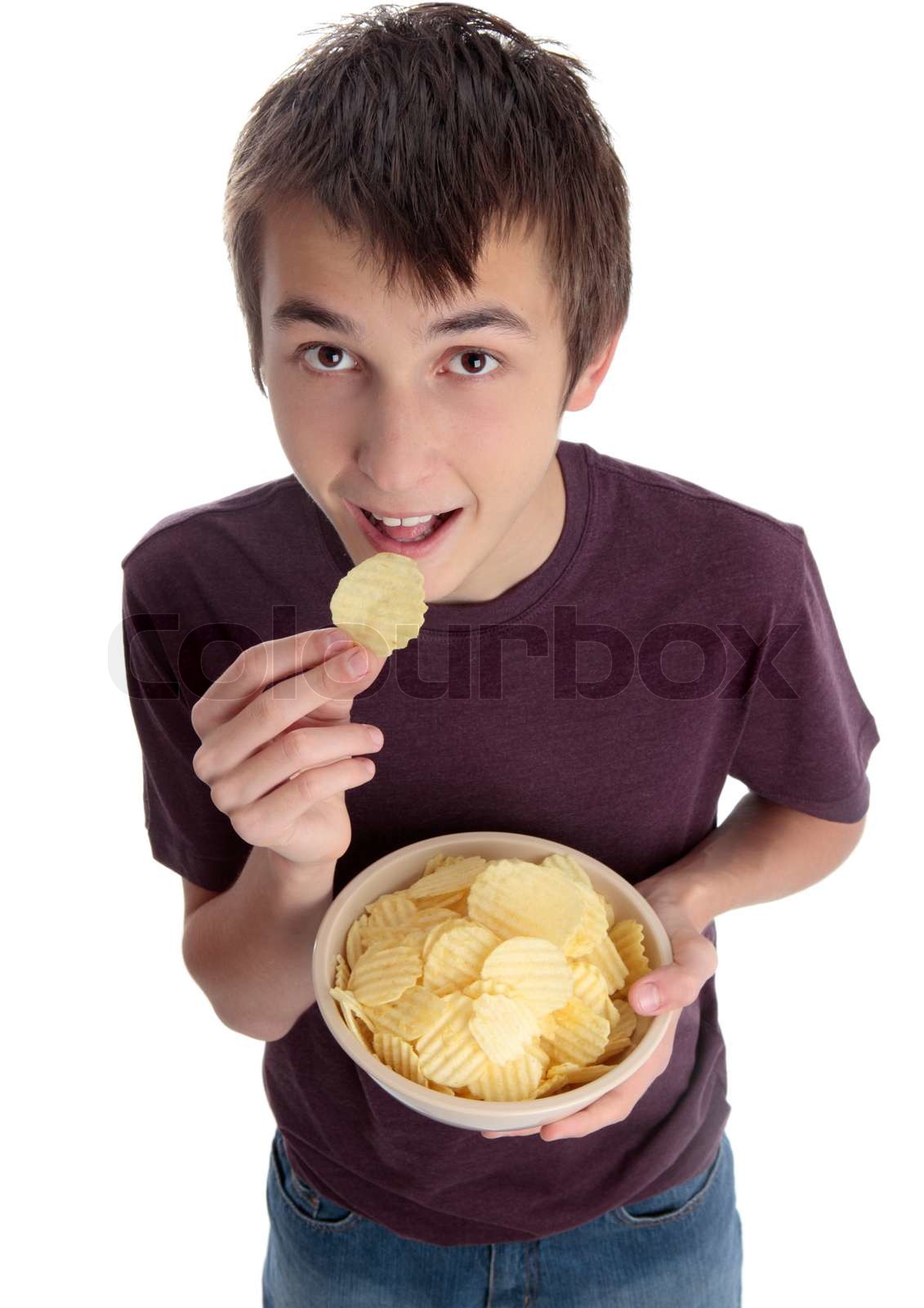 A boy eating crispy potato chips snack and looking up | Stock image ...