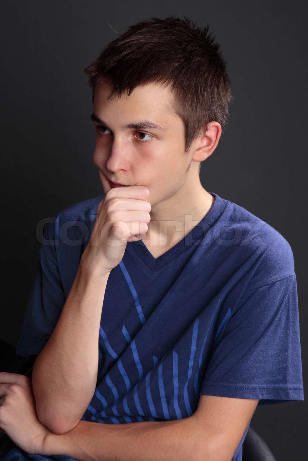 A boy sitting and thinking intensely | Stock image | Colourbox