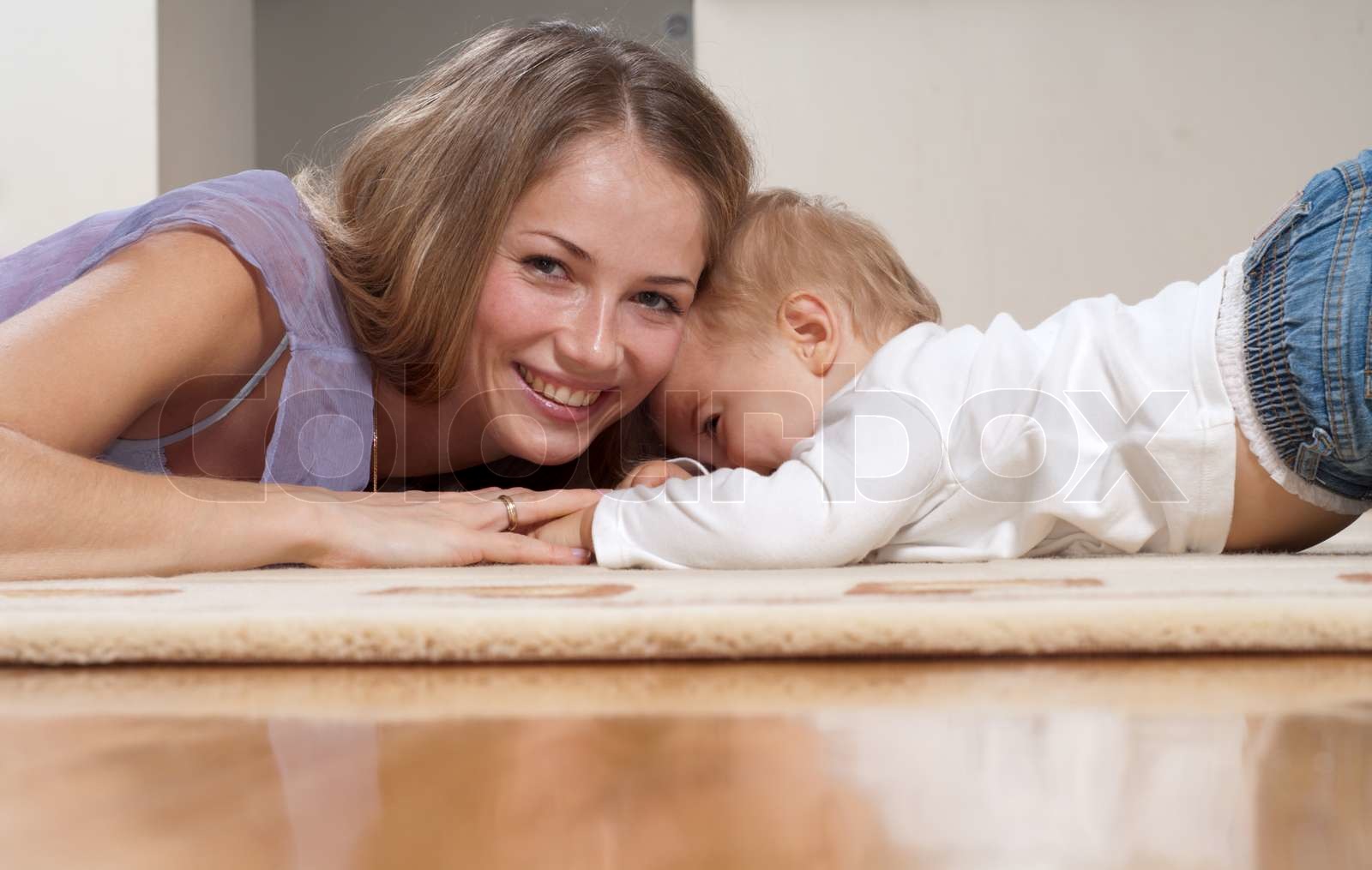 Young mother is lying down with her playful son | Stock image | Colourbox